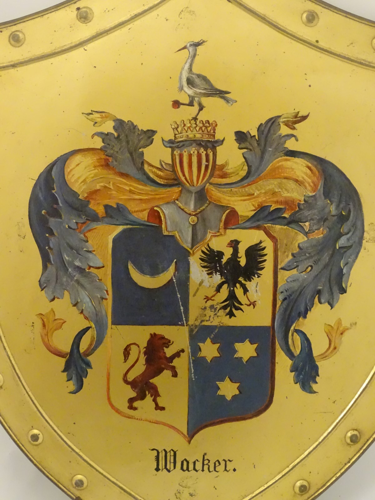 A 20thC tin plate heraldic shield wall plaque, bearing the coat of arms ...