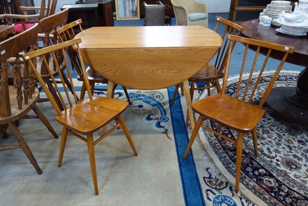 ERCOL: An oval drop flap dining table, 125cm wide (open) and four Ercol ...