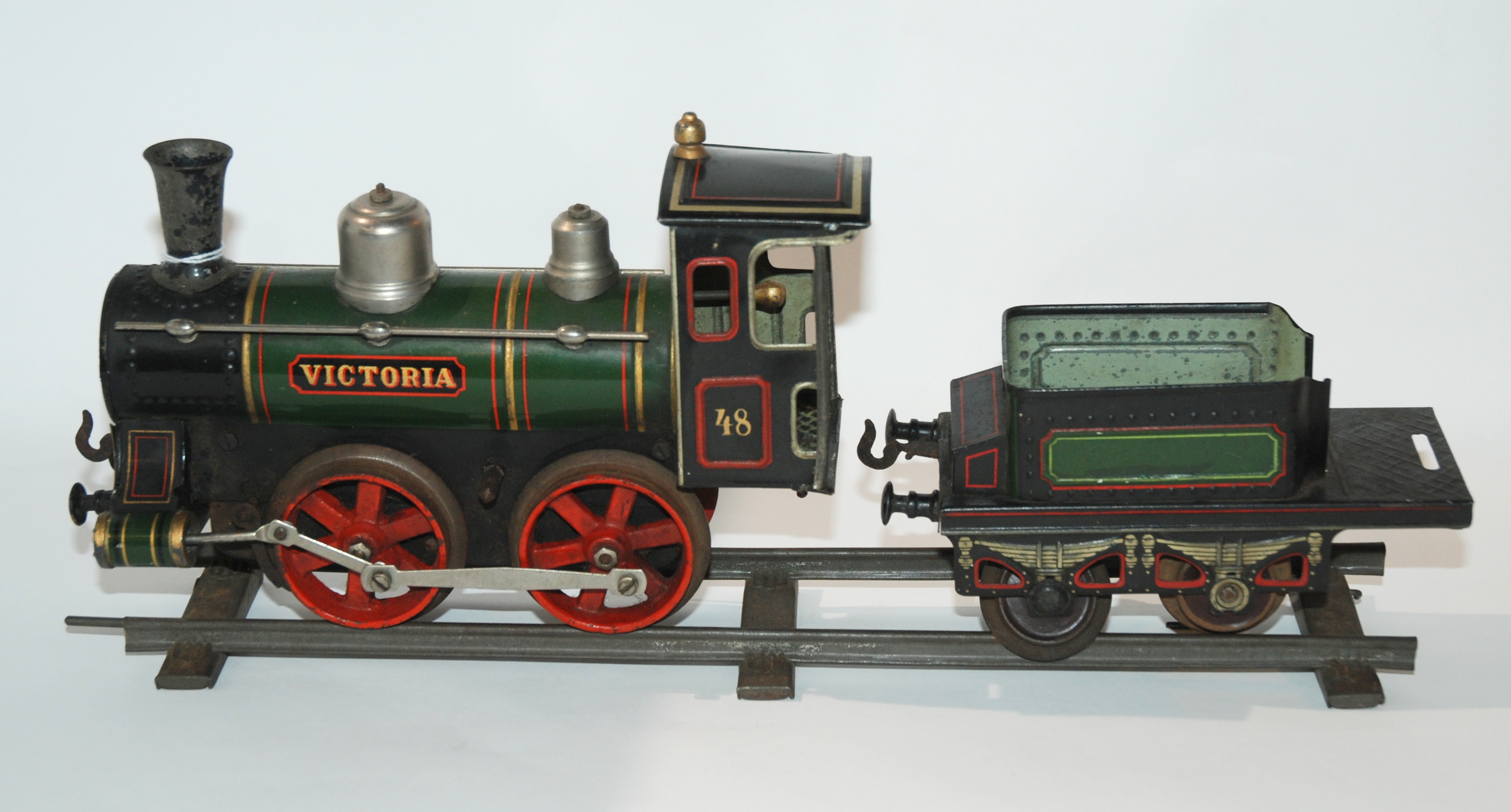 A vintage Bing tinplate clockwork locomotive with tender, two coaches ...