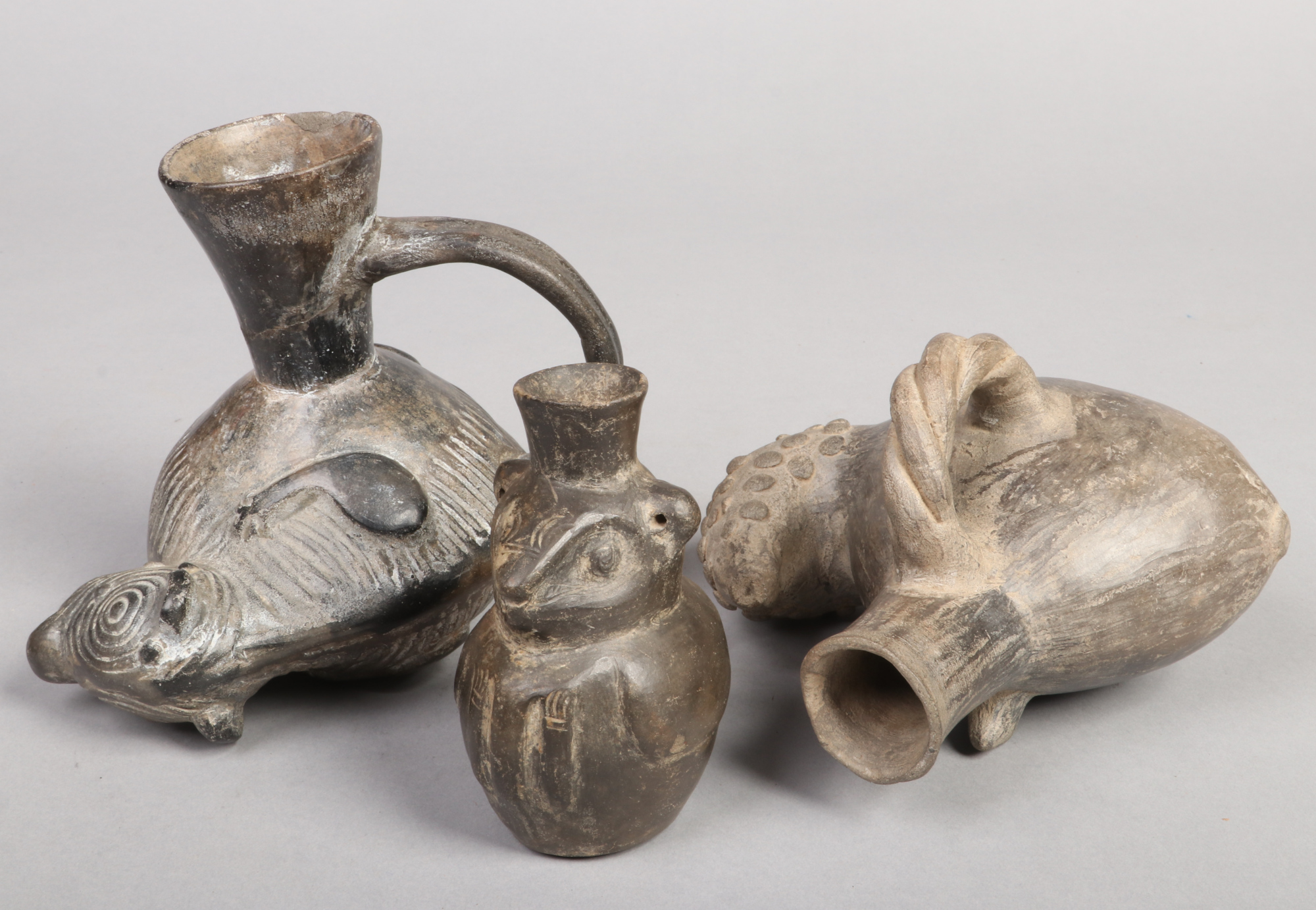 Three Peruvian black pottery zoomorphic flasks. Largest 15cm. Smallest ...