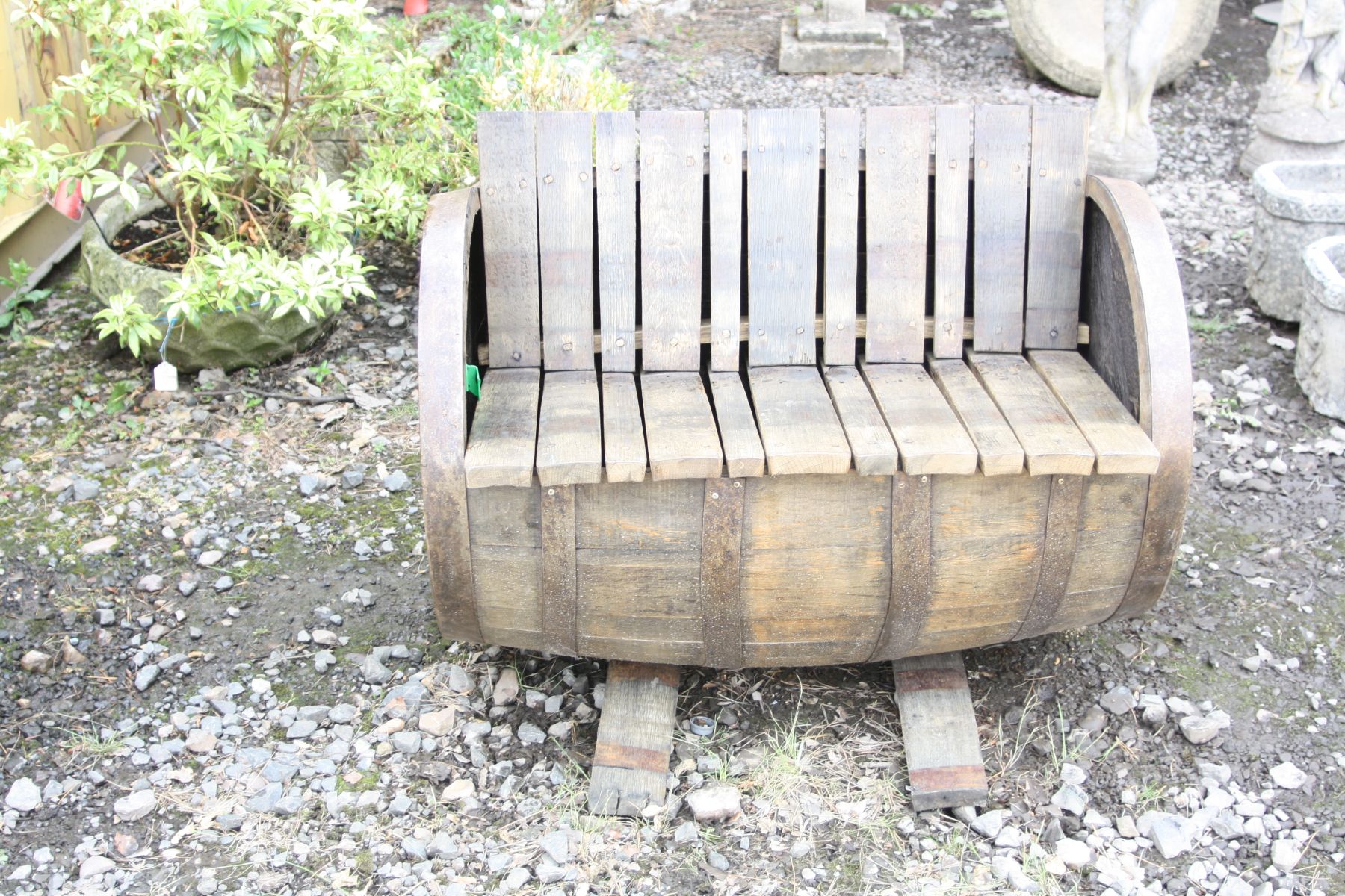 A BOURBON WHISKEY BARREL GARDEN BENCH with barrel staves as seat, back ...