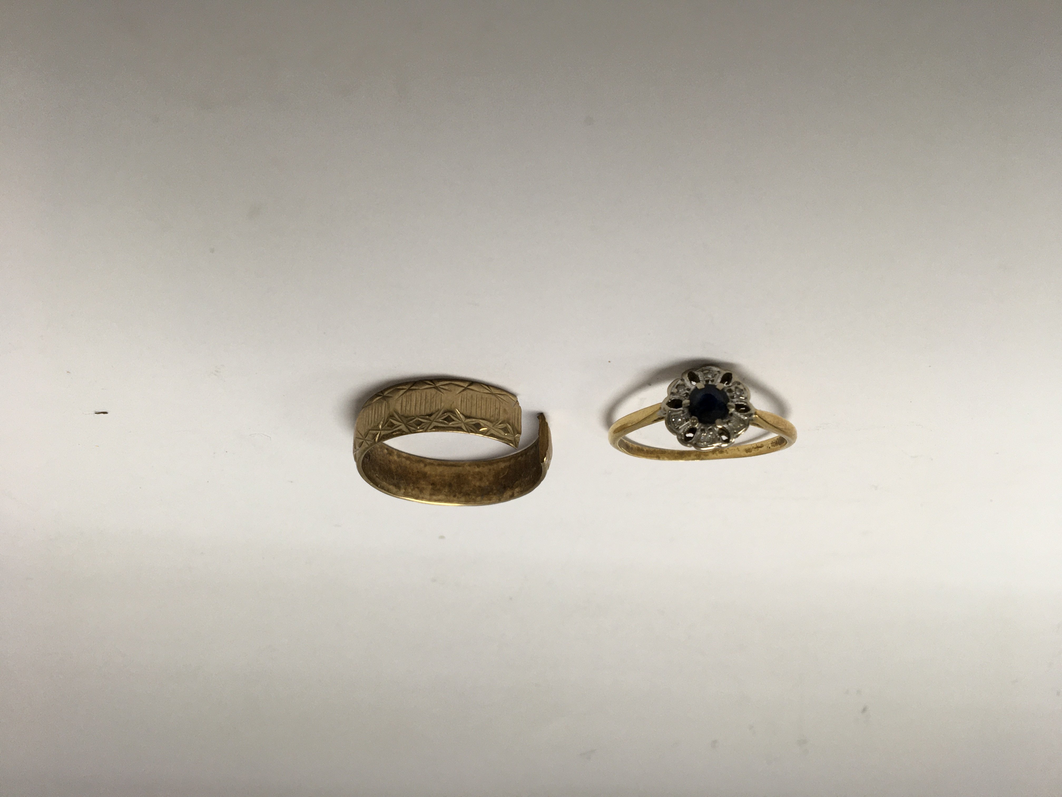 A 18 ct gold ring inset with central sapphire and a 9 ct gold band