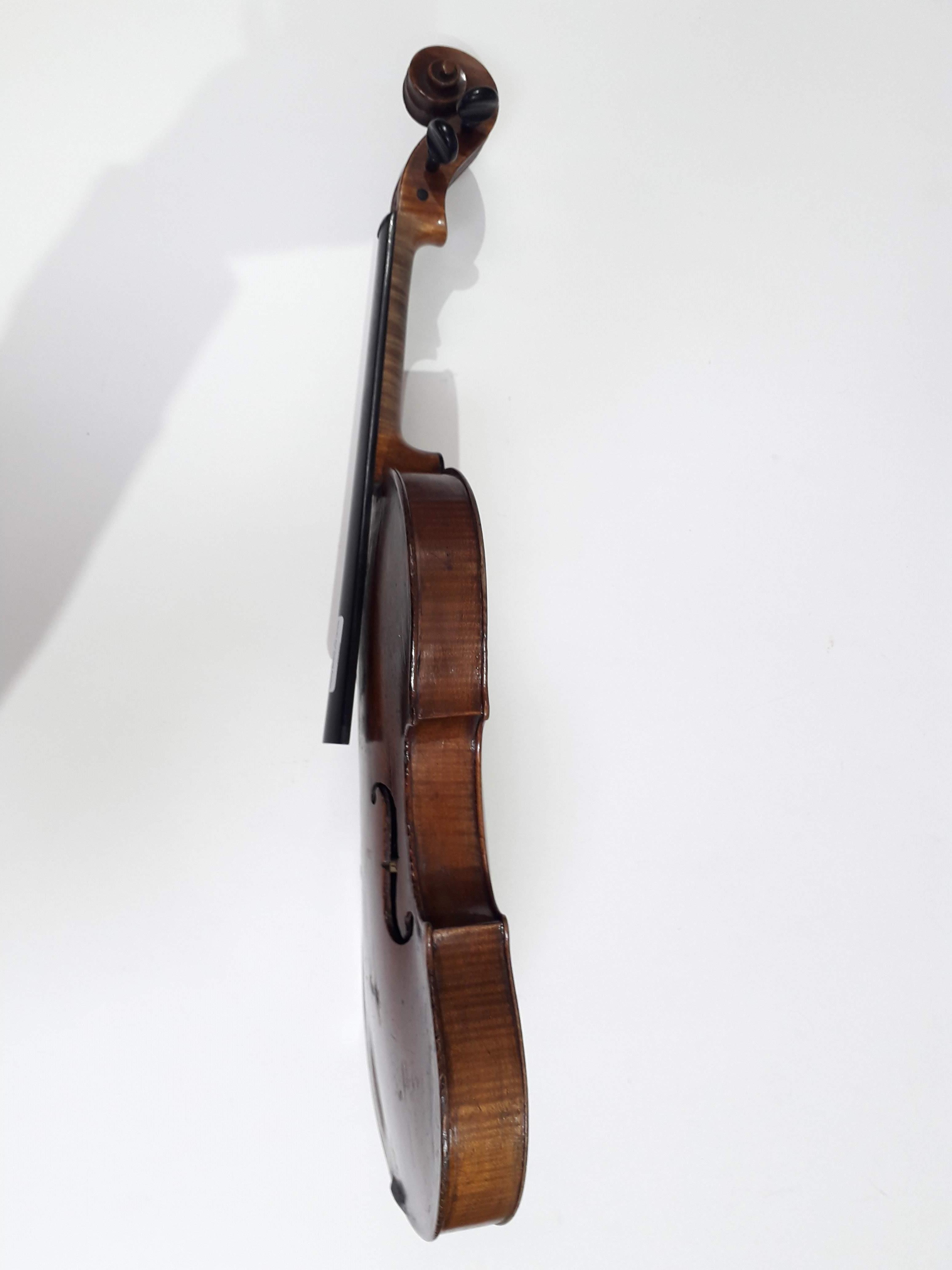 An antique violin with one piece back length 36cm bearing remains of ...