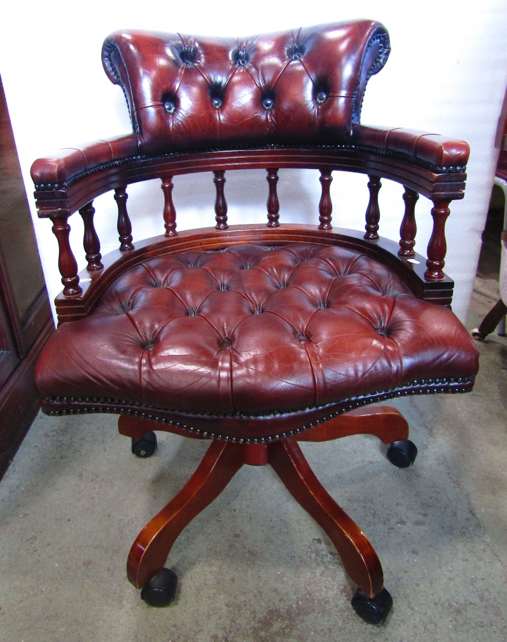 A reproduction captains type swivel desk chair, with button leather ...