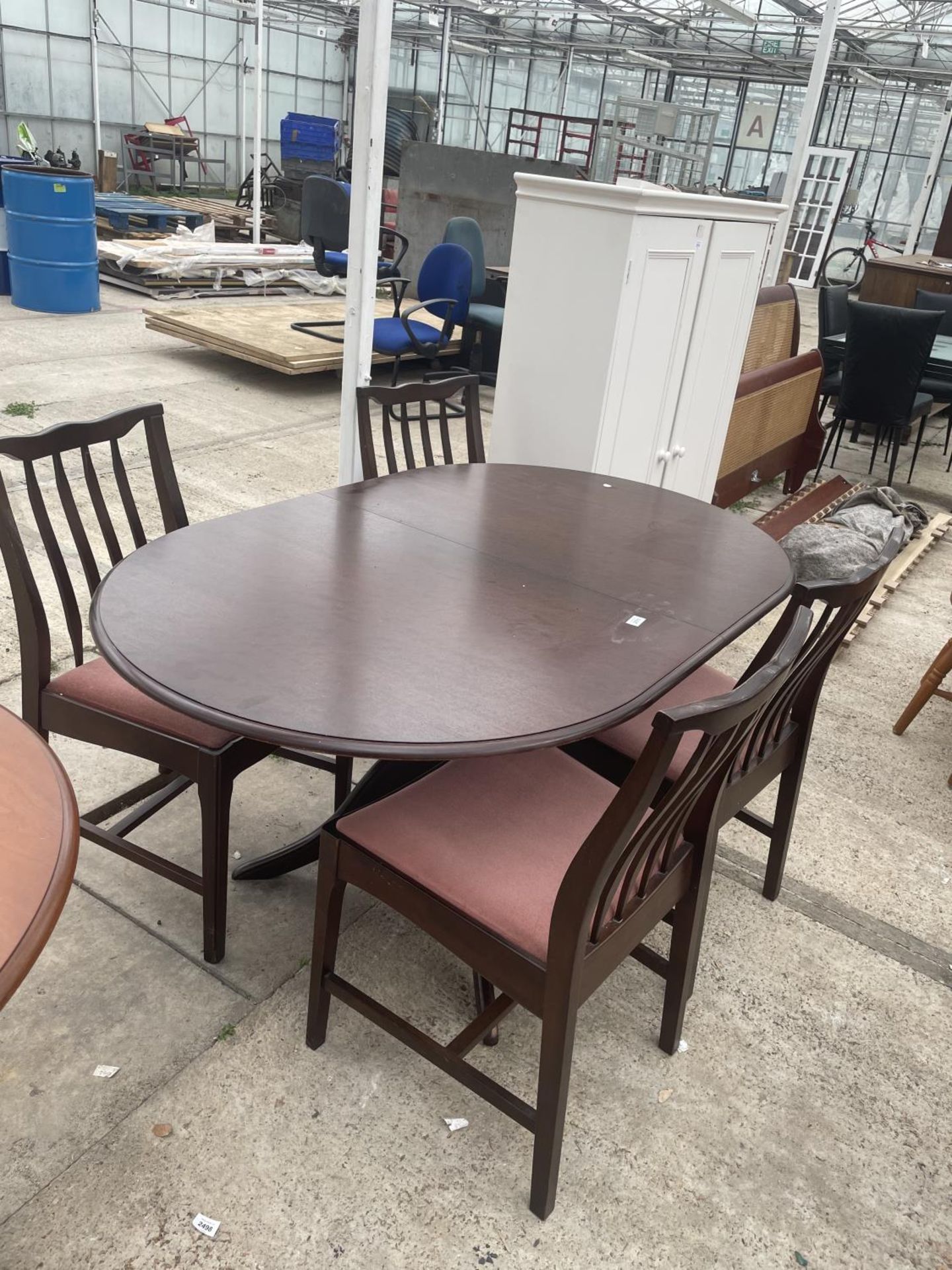 A STAG STYLE EXTENDING DINING TABLE AND FOUR CHAIRS