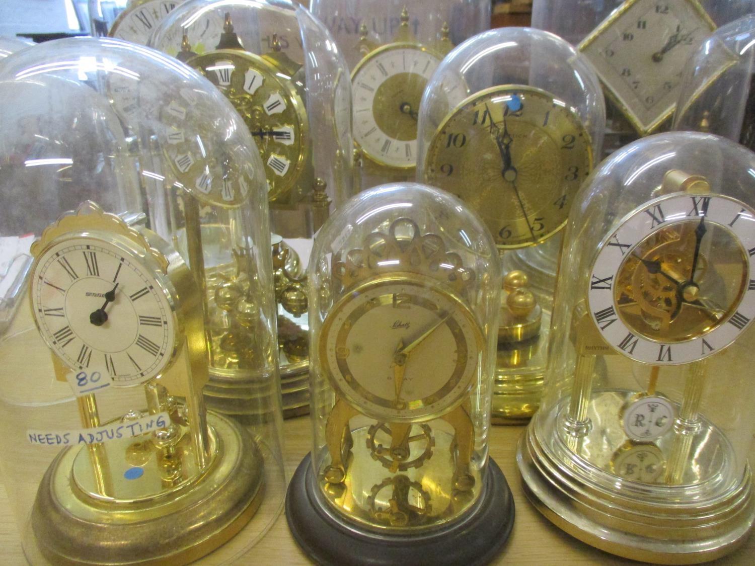 Eight anniversary clocks with glass and plastic domes, together with ...
