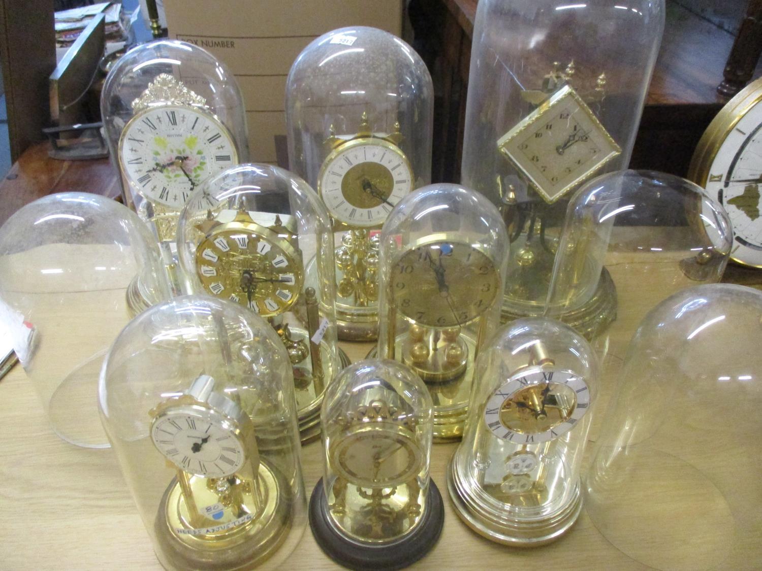 Eight anniversary clocks with glass and plastic domes, together with ...