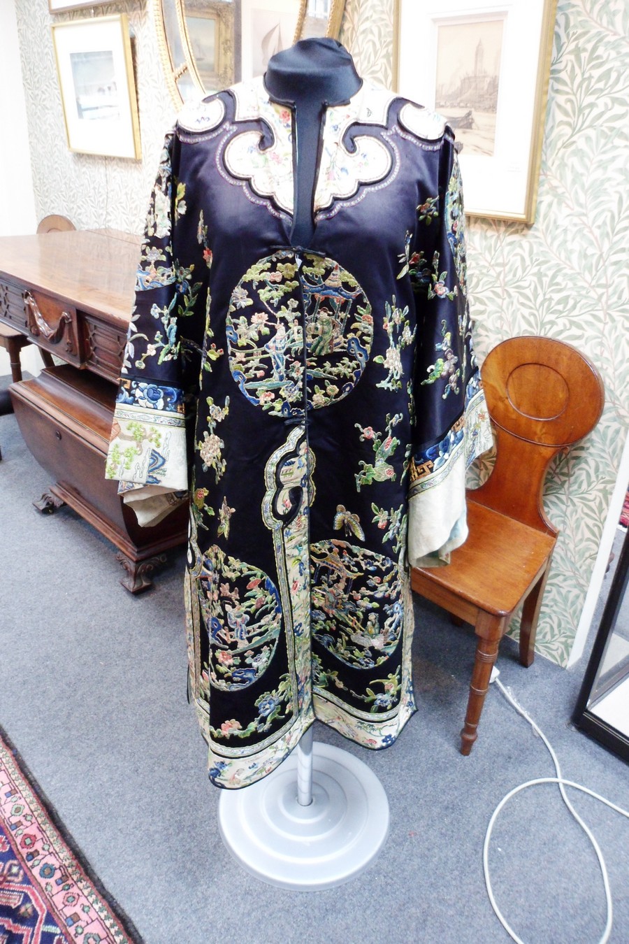 A Chinese mandarin robe, circa 1870, dark blue with roundels of ladies ...