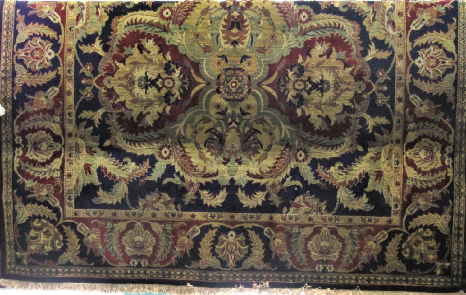 A Belgian wool carpet with scrolled acanthus detail upon a navy blue ...