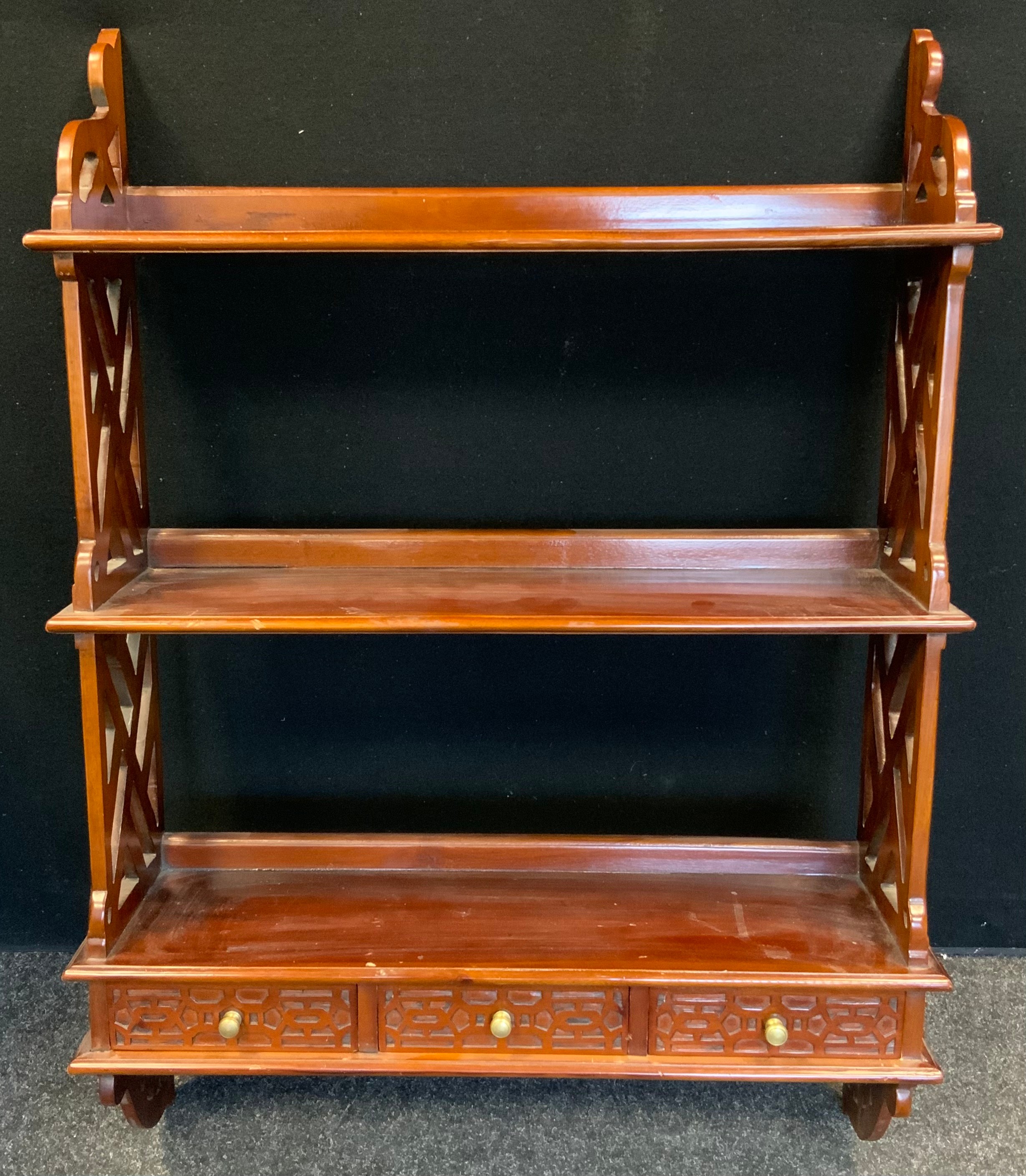 A contemporary mahogany wall hanging shelves, three fret drawers, 91cm ...
