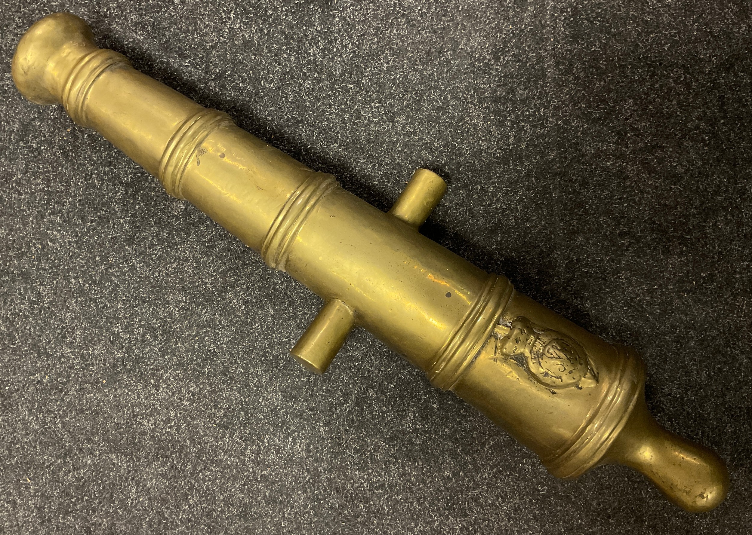 A replica brass cannon barrel, cast with coat of arms, 79cm long