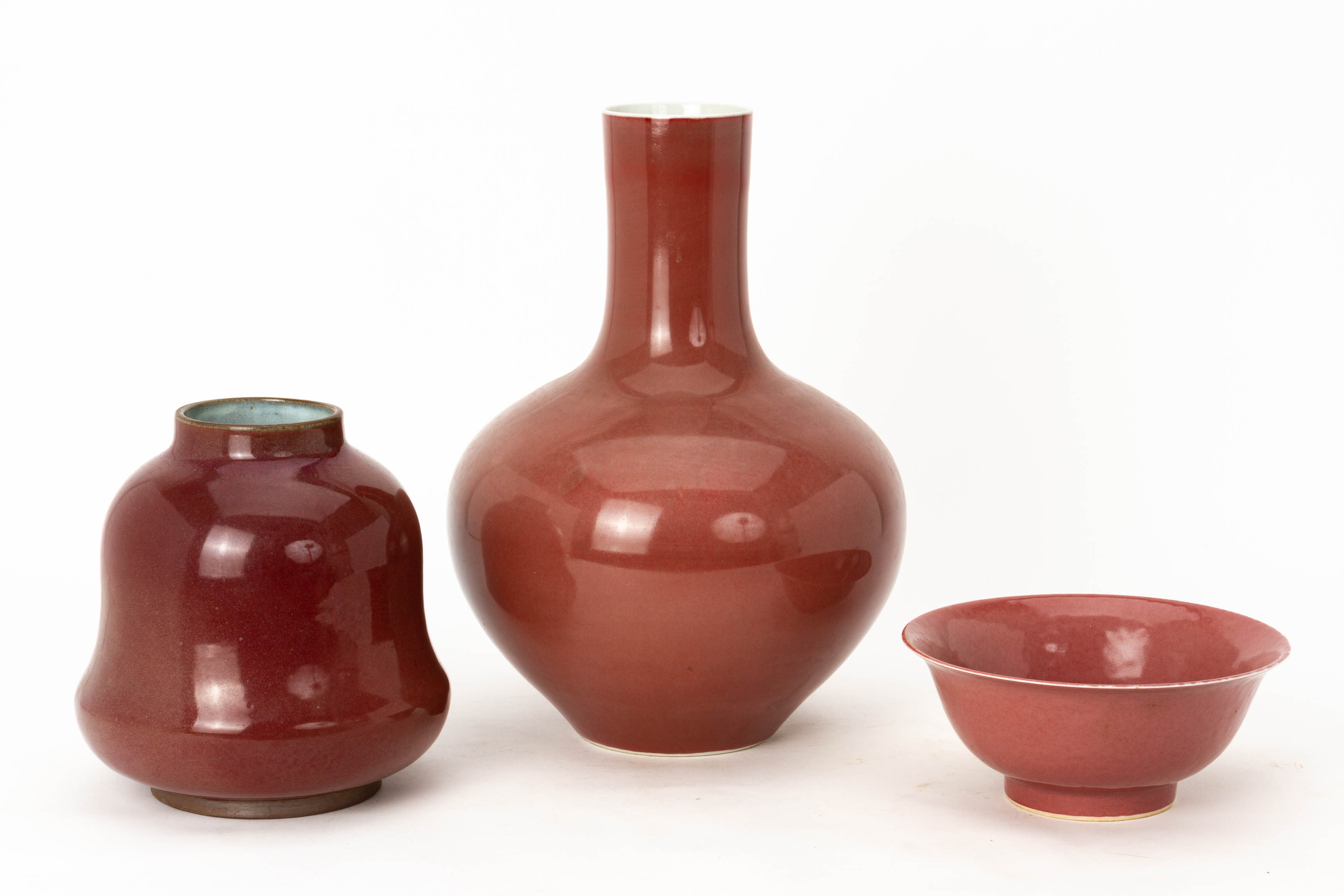THREE MONOCHROME RED GLAZED PORCELAIN ITEMS .Comprising a bottle vase ...