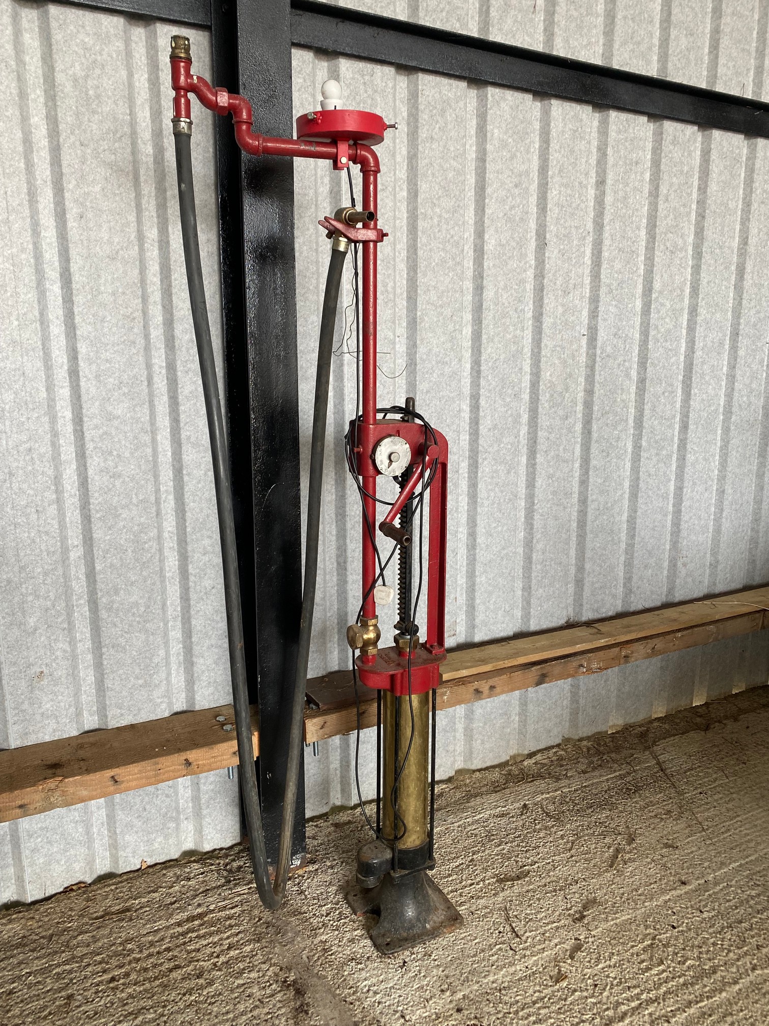 A Canadian skeleton petrol pump, probably a Wayne, with a rubber hose ...
