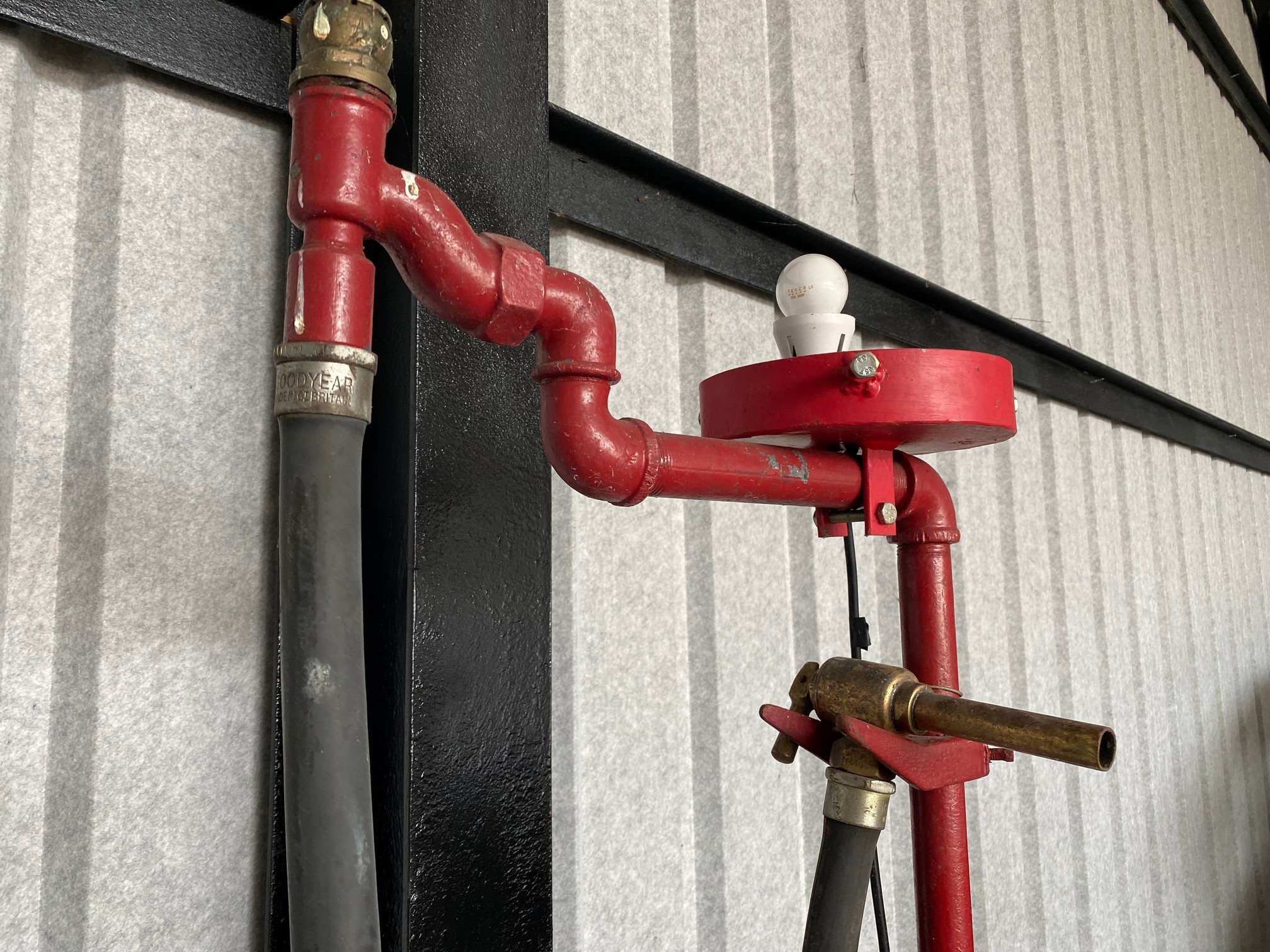 A Canadian skeleton petrol pump, probably a Wayne, with a rubber hose ...