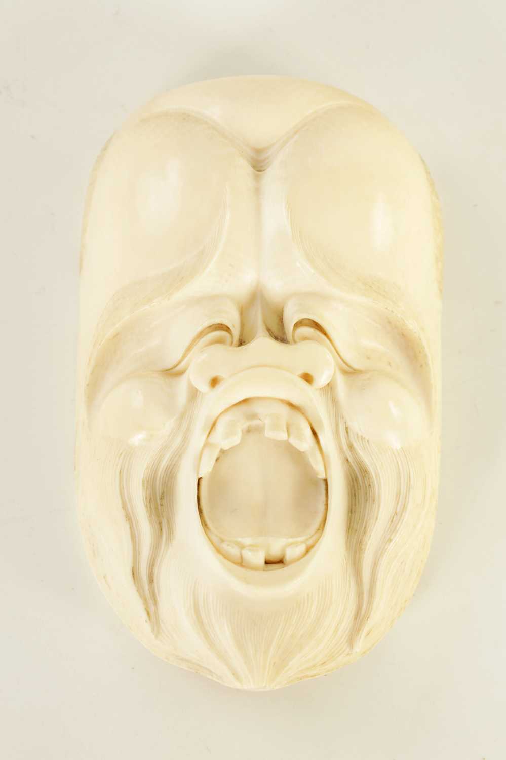 A JAPANESE MEIJI PERIOD CARVED IVORY GROTESQUE FACE MARK with four ...
