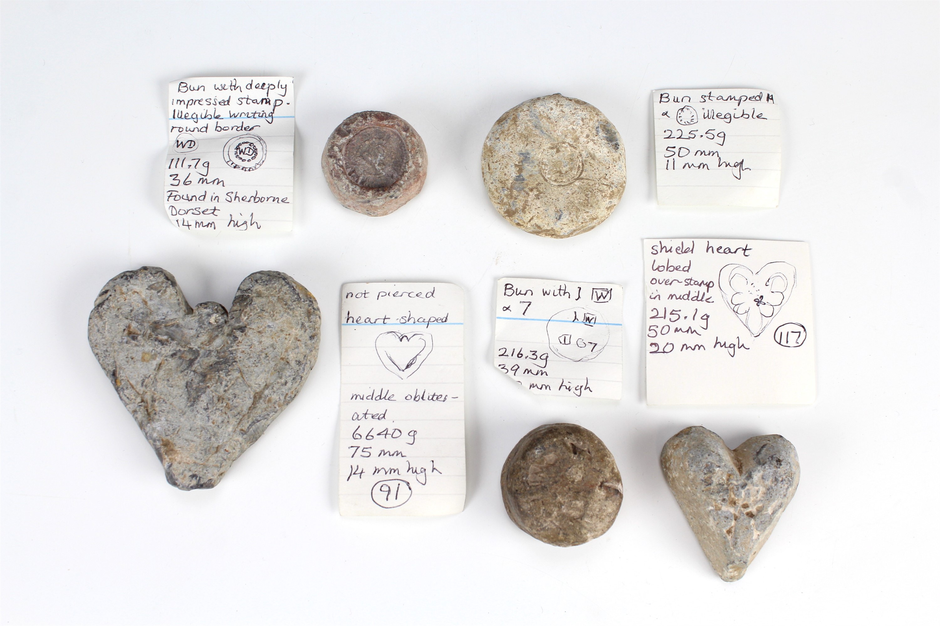 Five Medieval lead trade weights, comprising two heart shaped, a bun ...