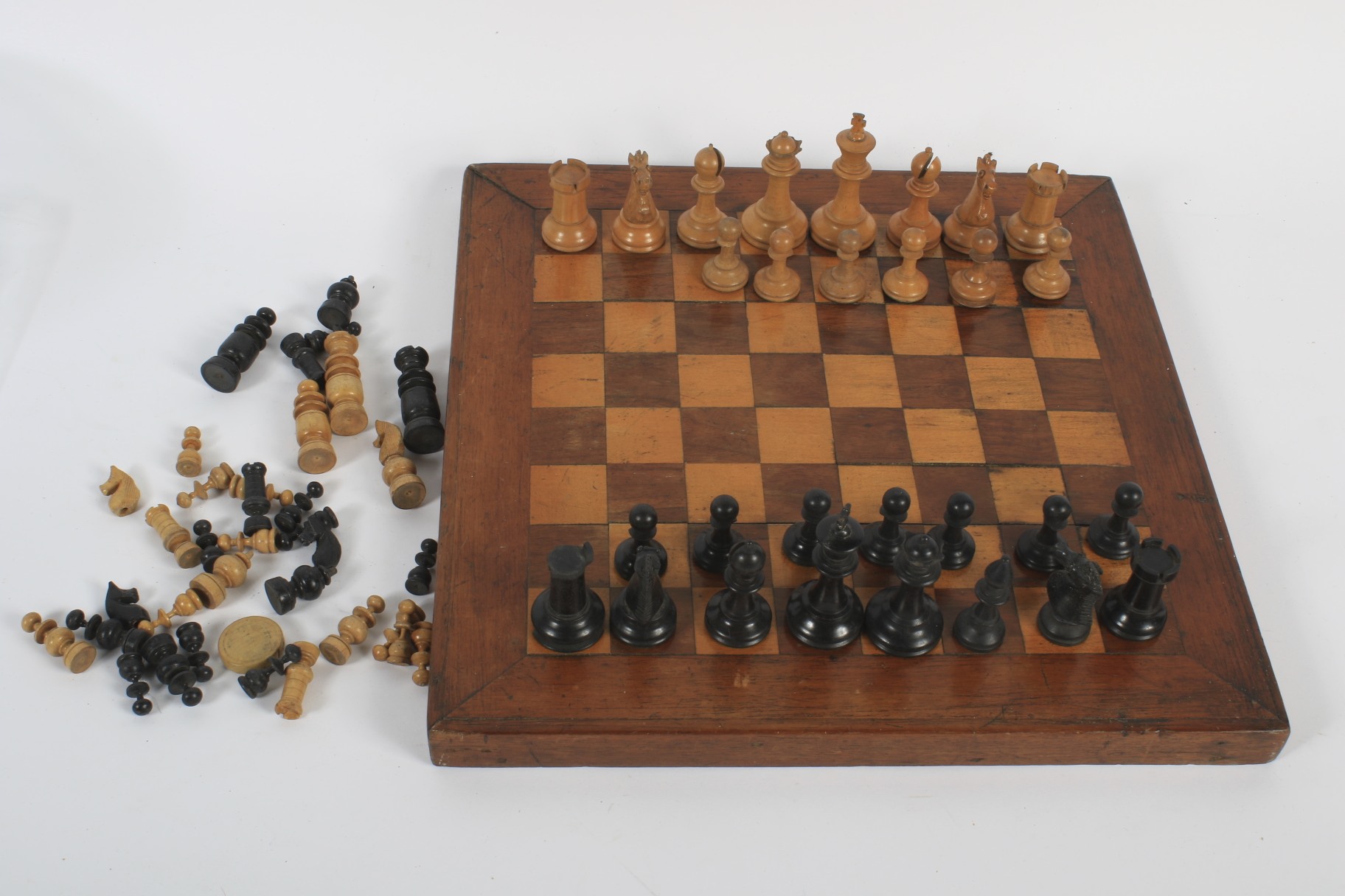 An early 20th century chess set and playing board dated to the verso ...
