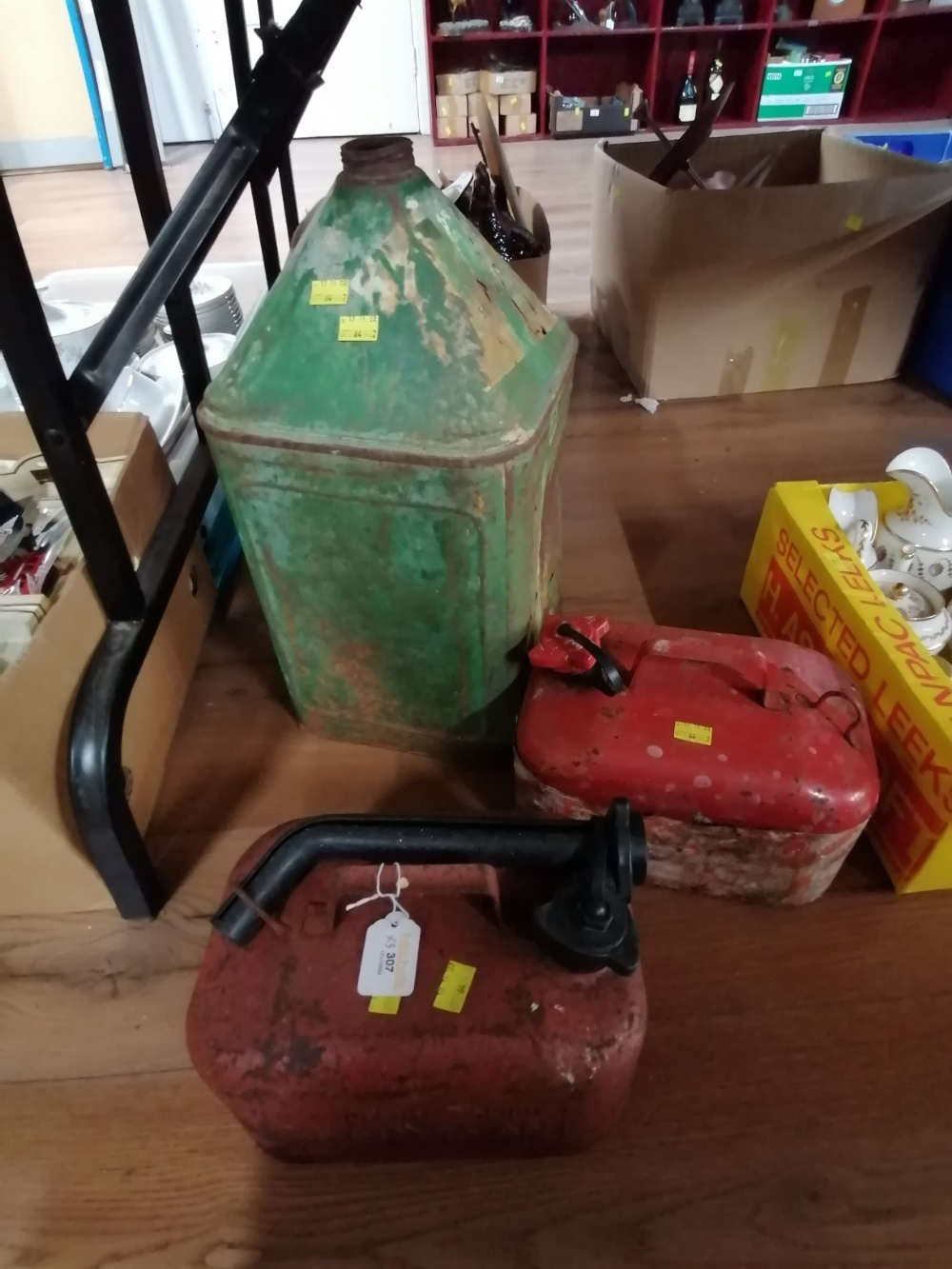 Two red metal petrol cans and vintage green petrol can