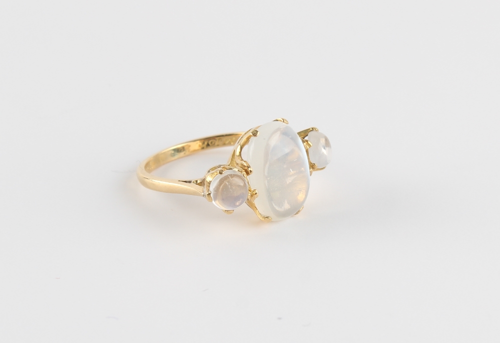 An unmarked high carat yellow gold moonstone three stone ring, the ...