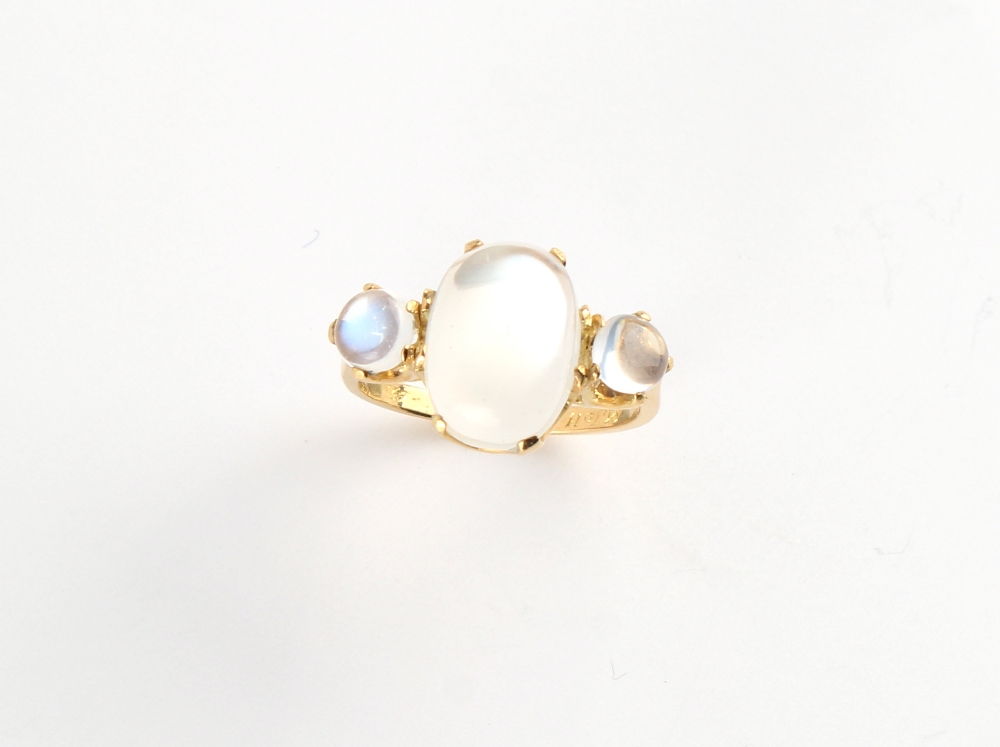 An unmarked high carat yellow gold moonstone three stone ring, the ...