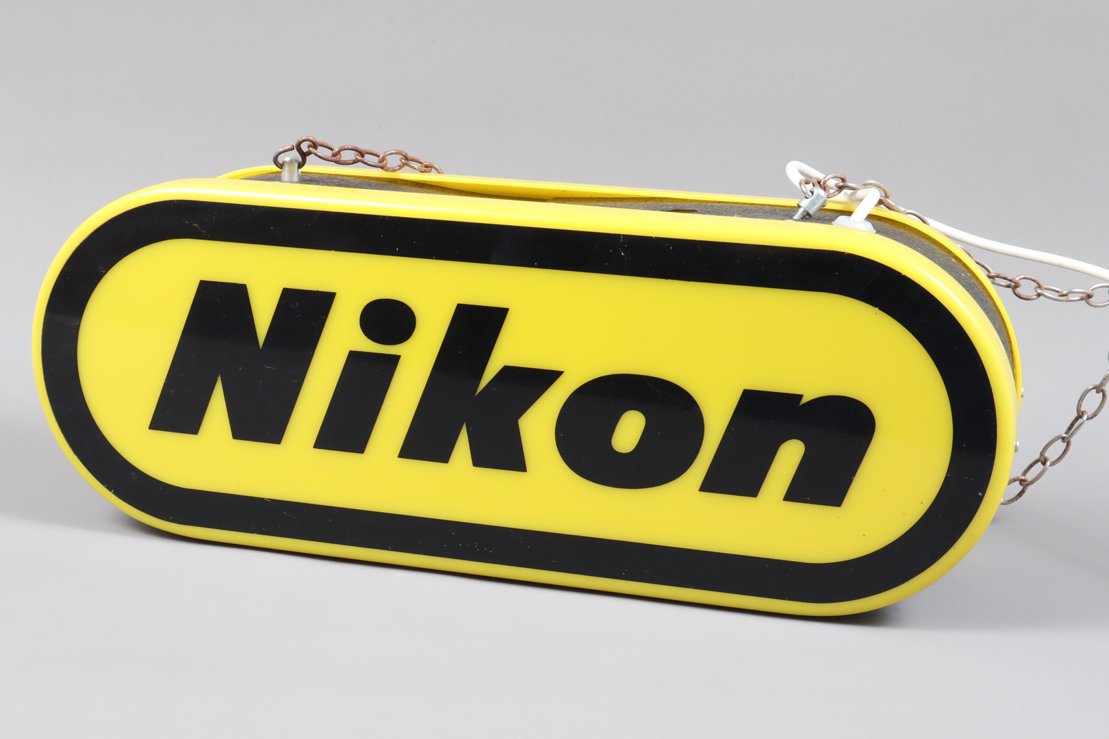 A Nikon Illuminated Shop Advertising Sign, with Nikon logo, yellow ...