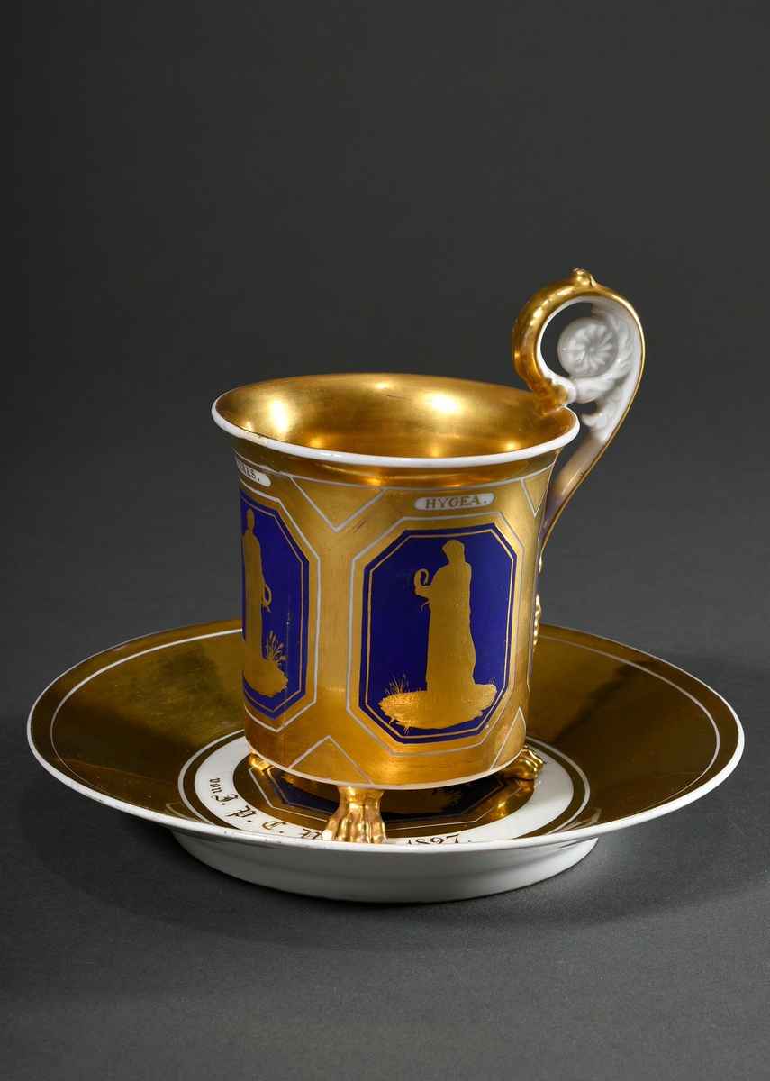 A richly gilded KPM Empire cup on paw feet with etched mythological ...