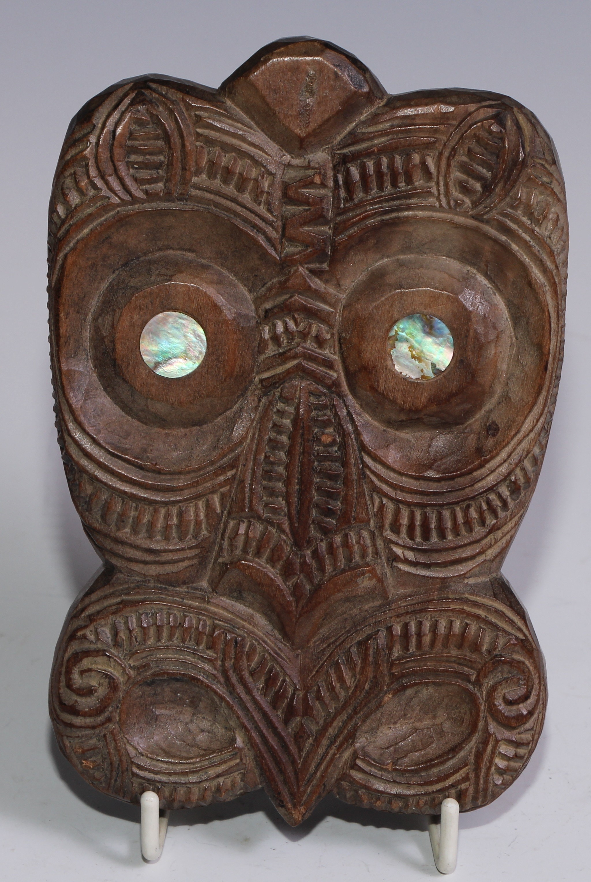A Maori carving, after a koruru gable mask, carved with stylized ...
