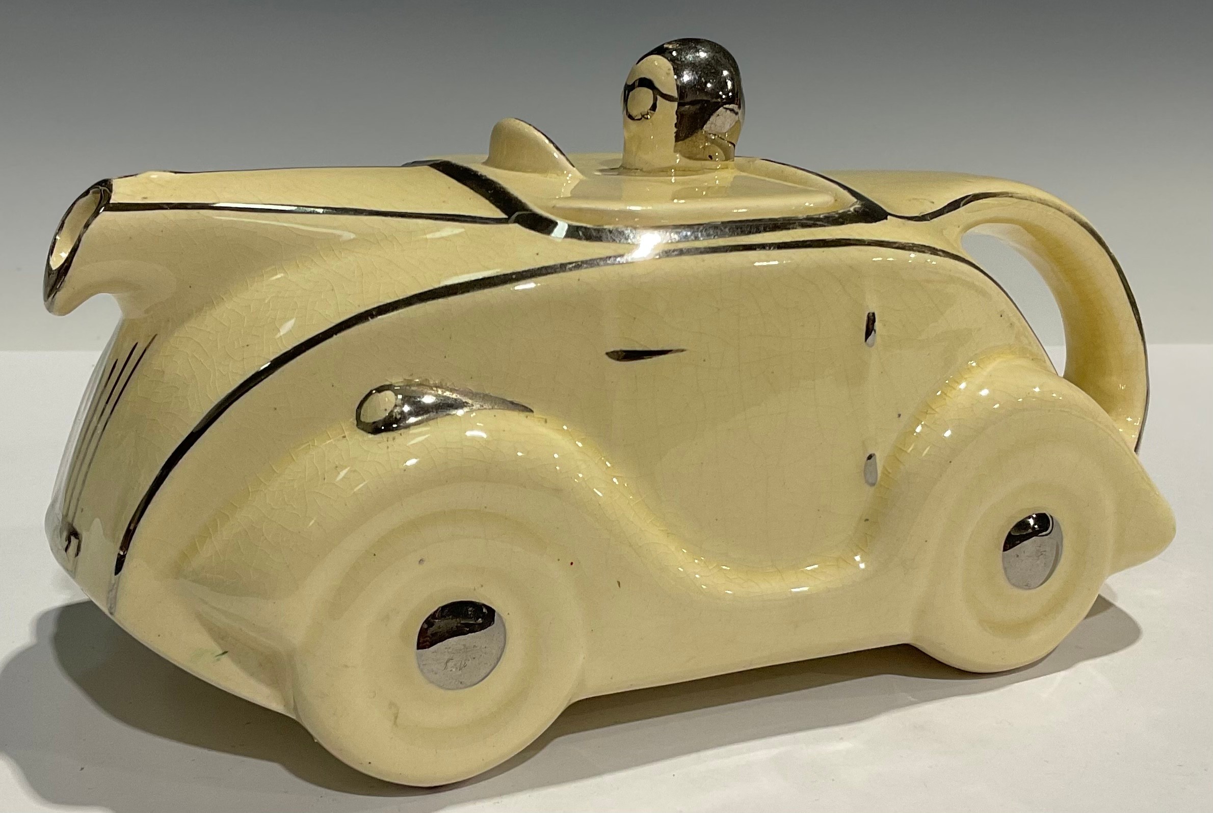 An Art Deco teapot, modelled as a racing car, 23cm long