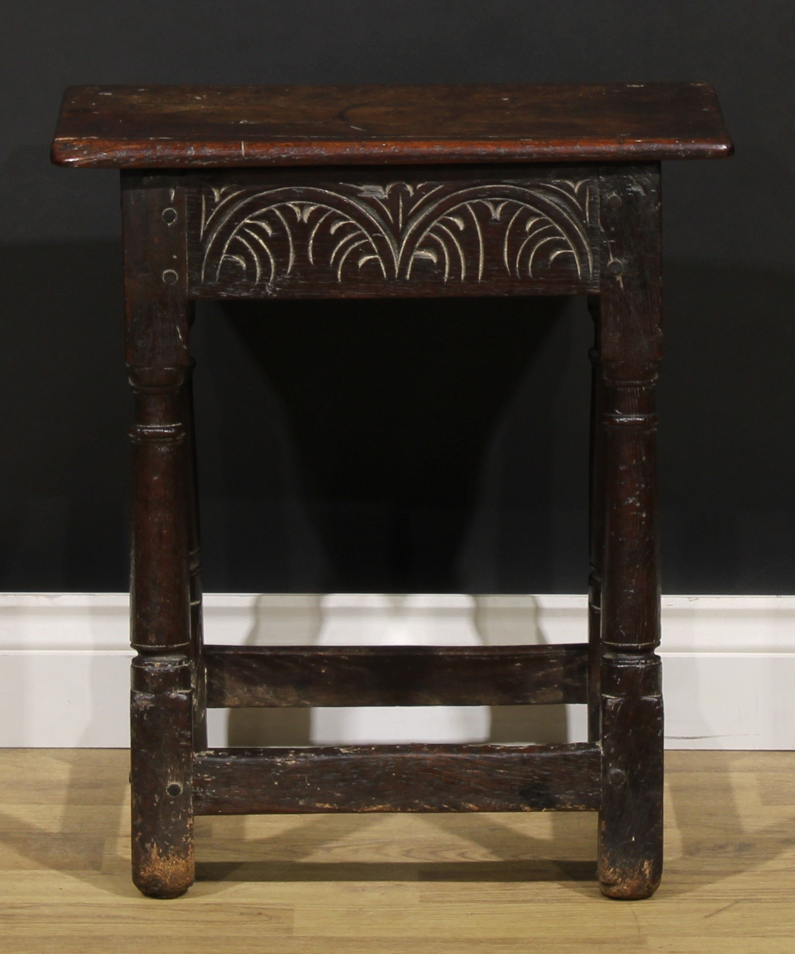 A Charles II oak joint stool, oversailing top above a deep frieze ...
