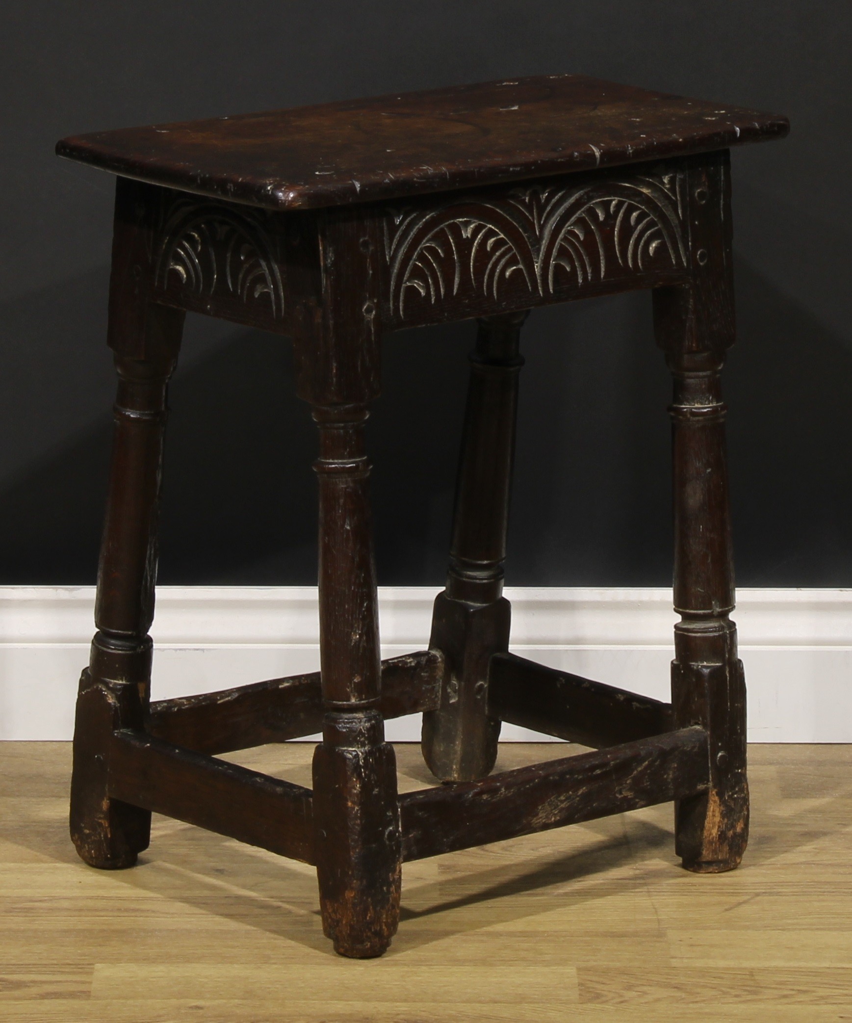 A Charles II oak joint stool, oversailing top above a deep frieze ...