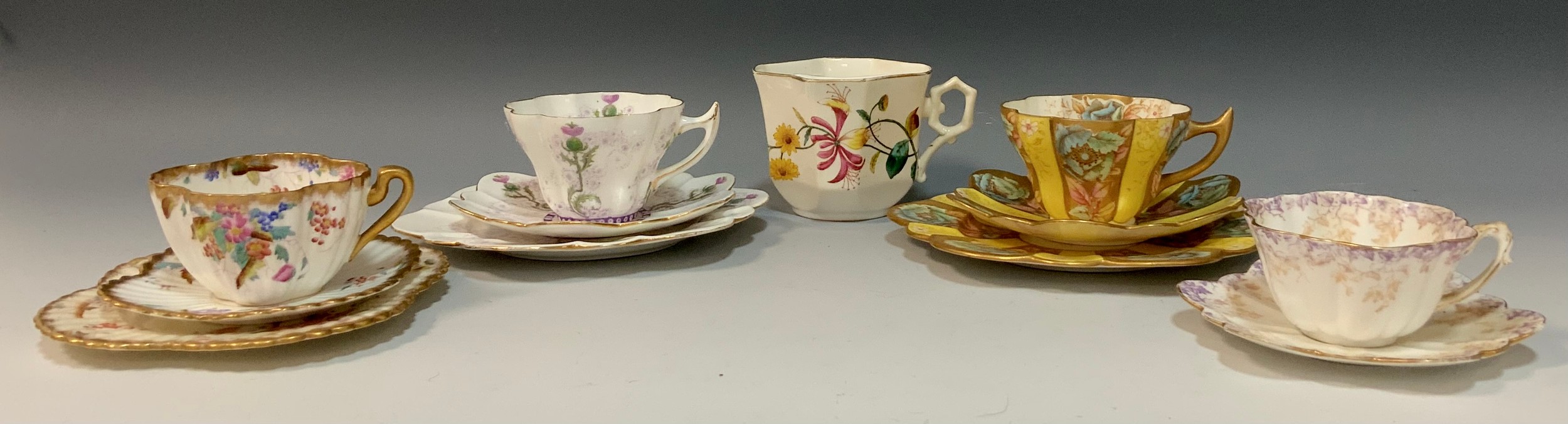 A group of three Wileman and Company tea cup trios; a 'Thistle' pattern ...