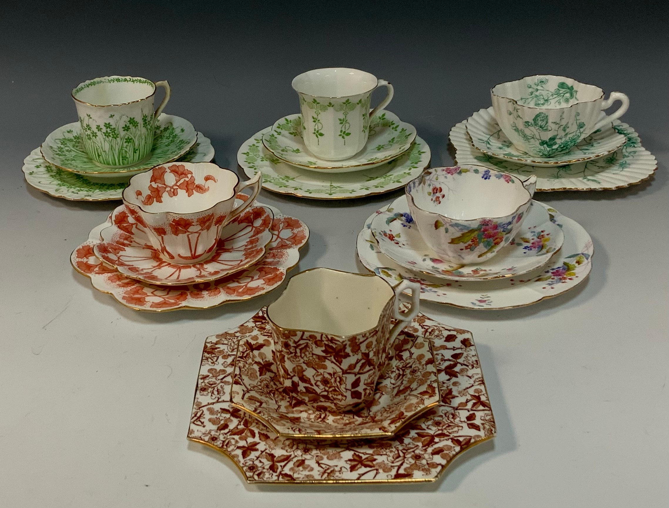 A group of six Wileman and Company tea cup trios including; a 'Dresden ...