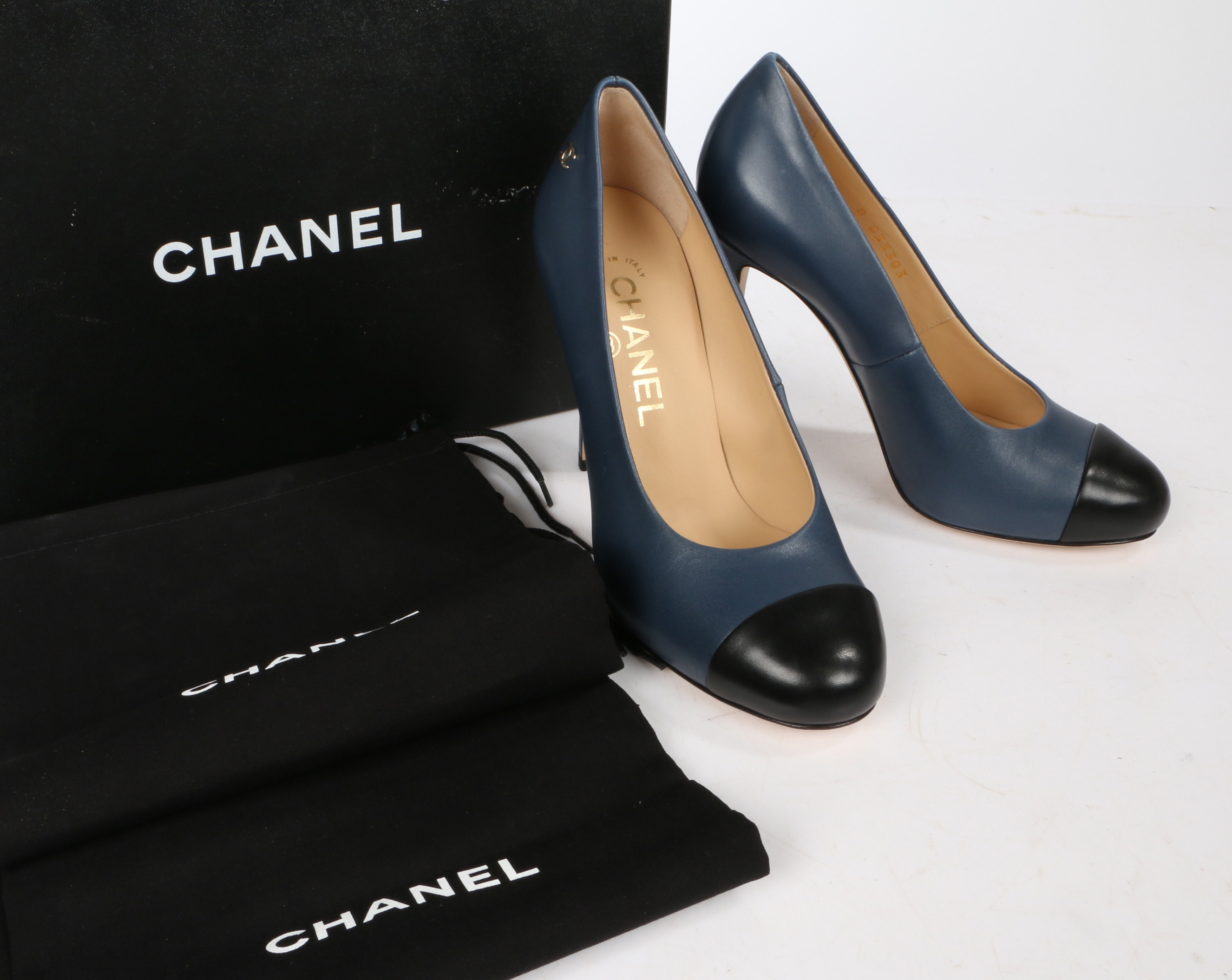 A pair of Chanel stiletto heeled blue leather sandals with black CC toe ...