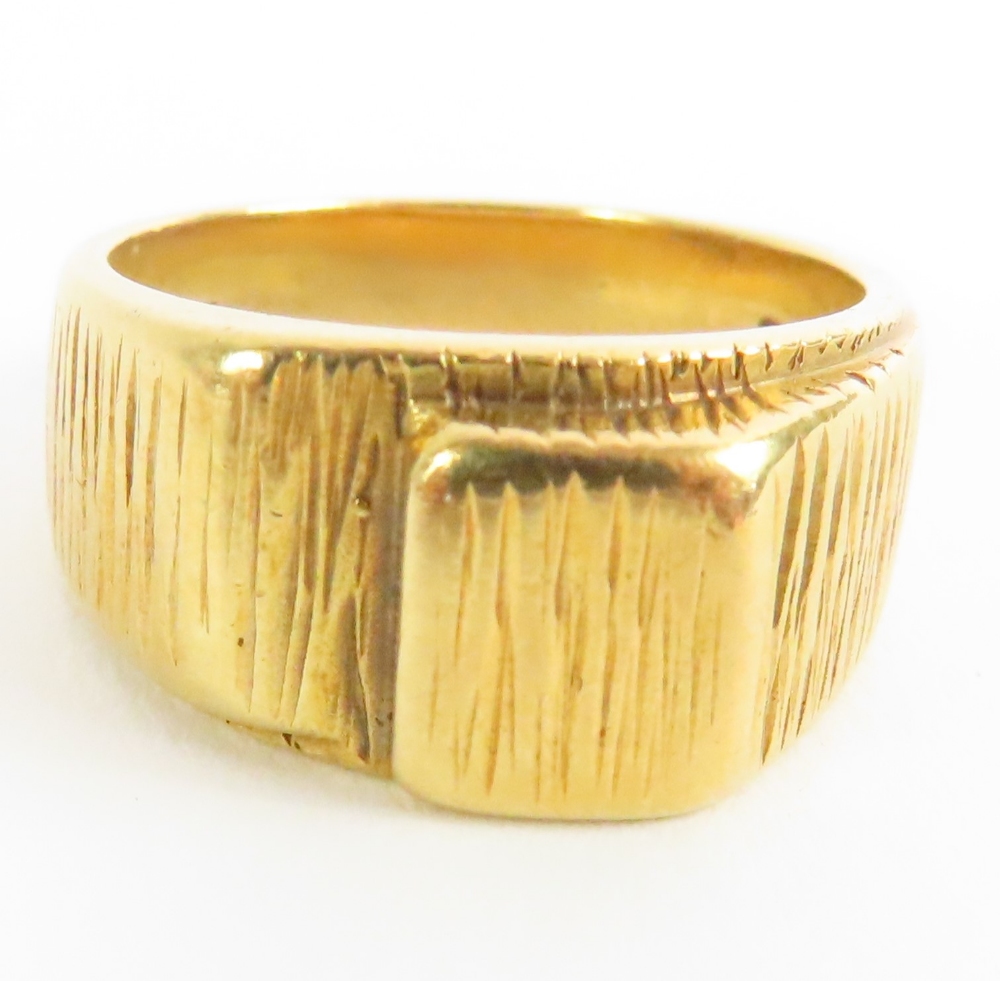 A heavy 18ct gold ring, stepped to the head and textured throughout ...