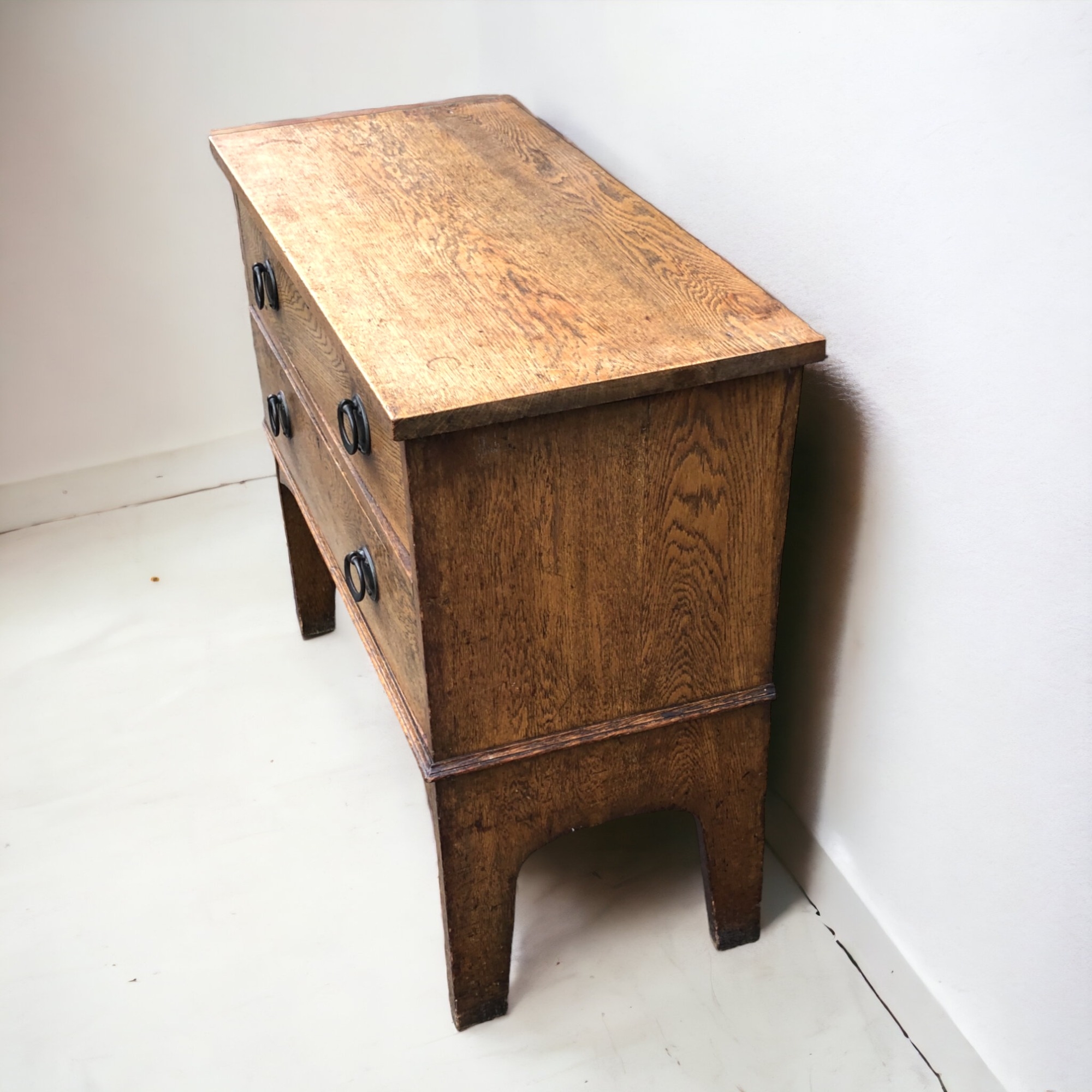 ARTS & CRAFTS OAK TWO-DRAWERS CHEST OF DRAWERS. ON RAISED FEET, WITH ...