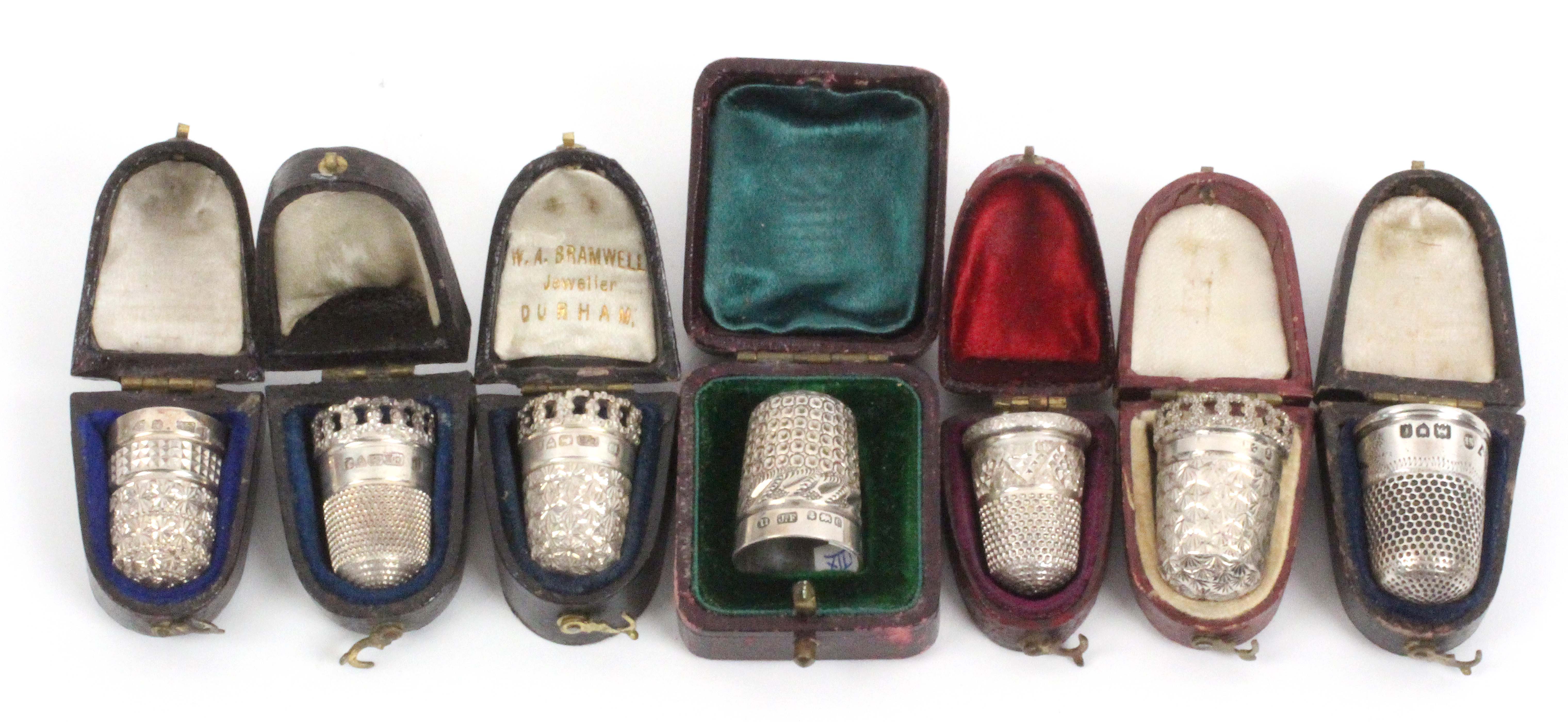 Seven English hallmarked silver thimbles, all in leather cases, three ...
