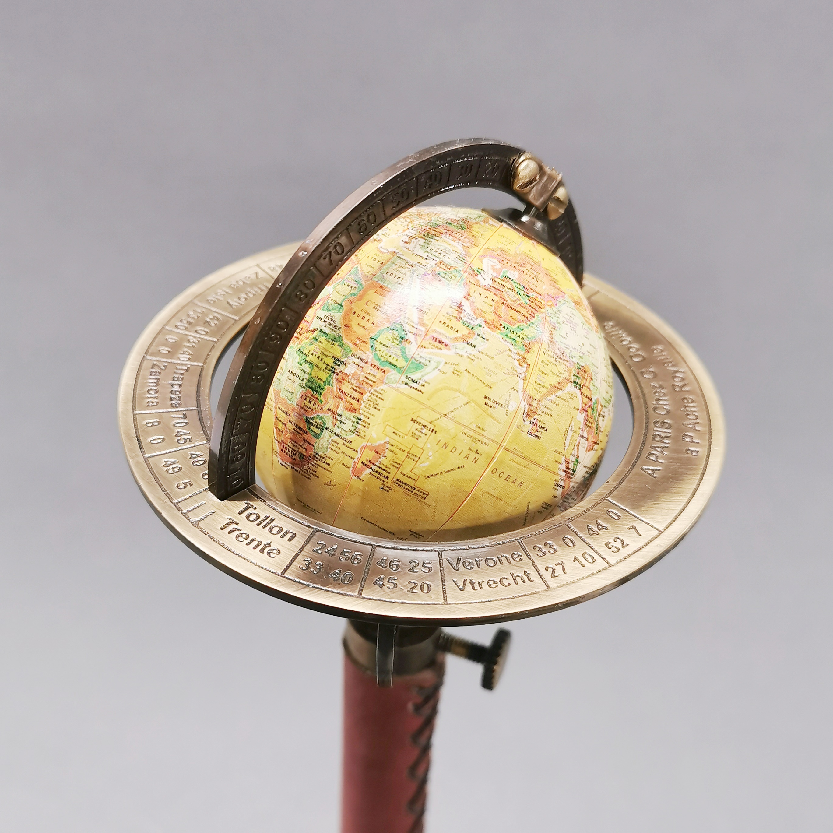 A small metal globe on stand, H. 29cm. Together with a brass ...