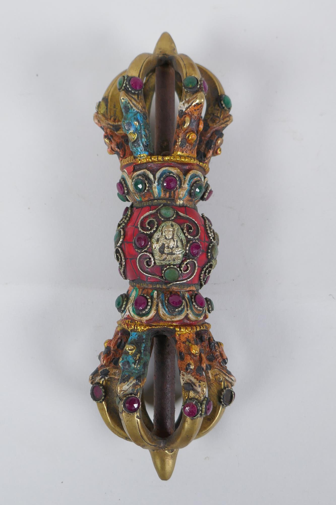 A Tibetan ceremonial bronze vajra with painted details and stone ...
