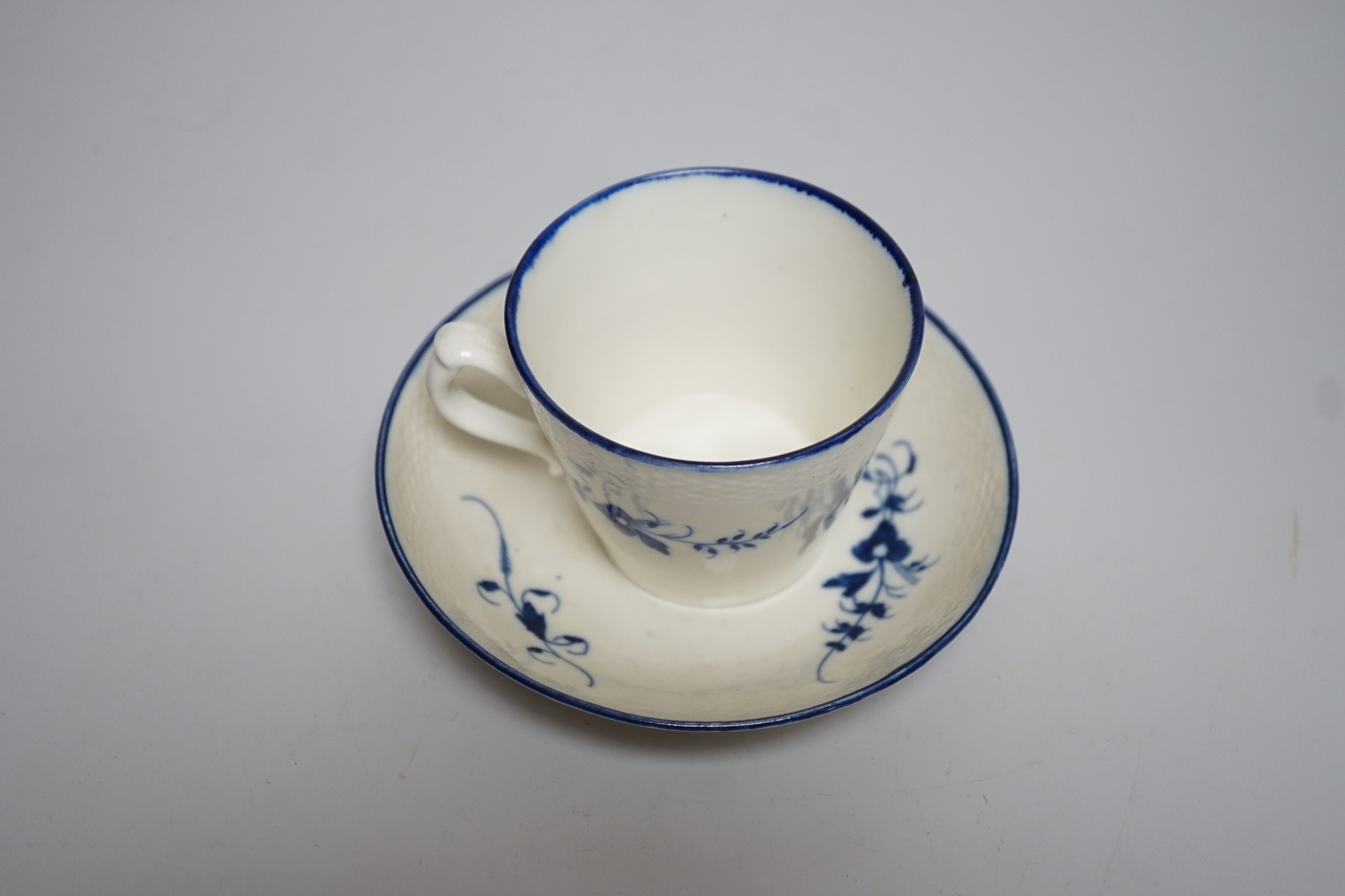 An 18th century Caughley coffee cup and saucer, Chantilly sprigs under ...