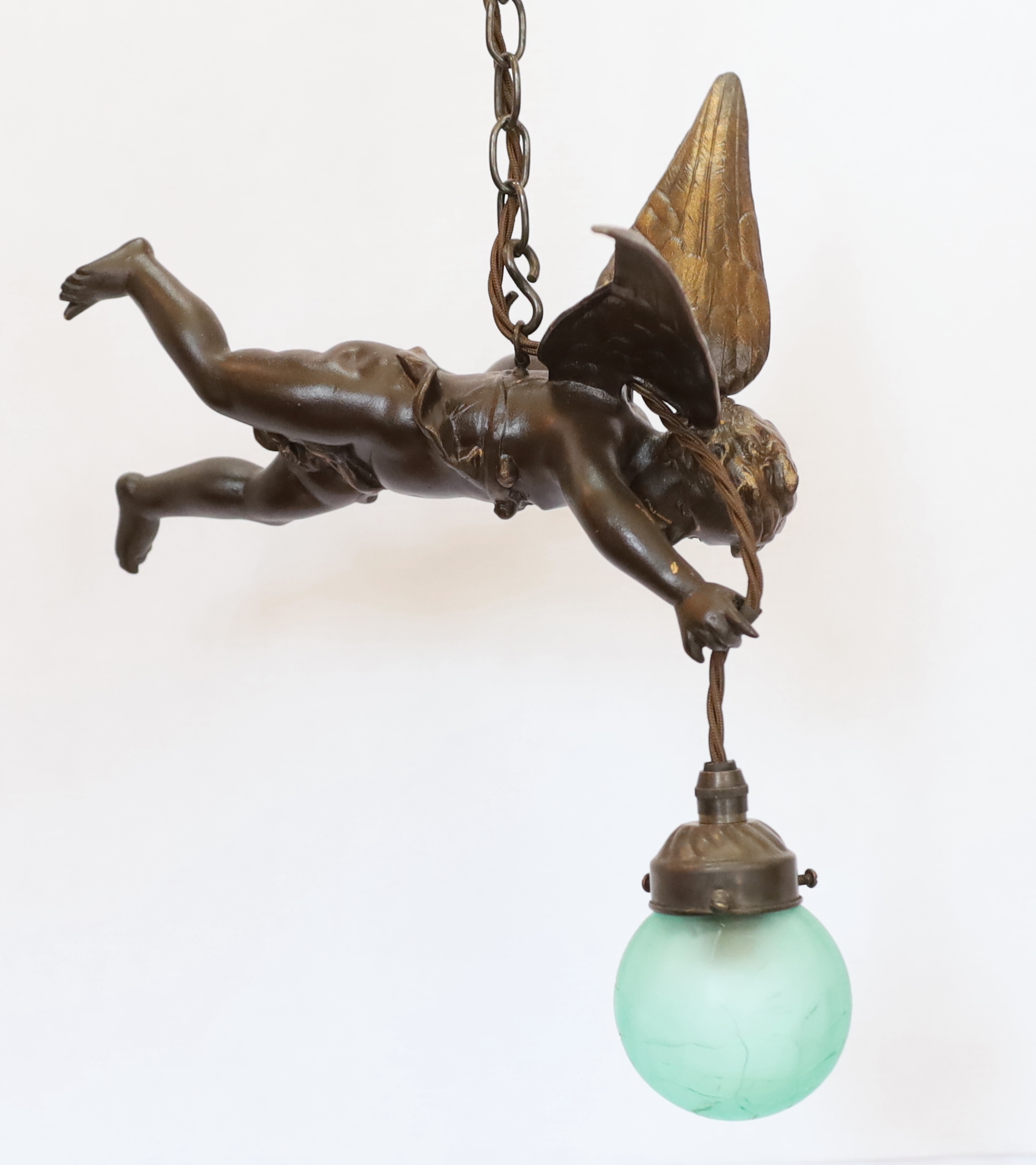 An early 20th century bronzed spelter cherub light fitting with green ...