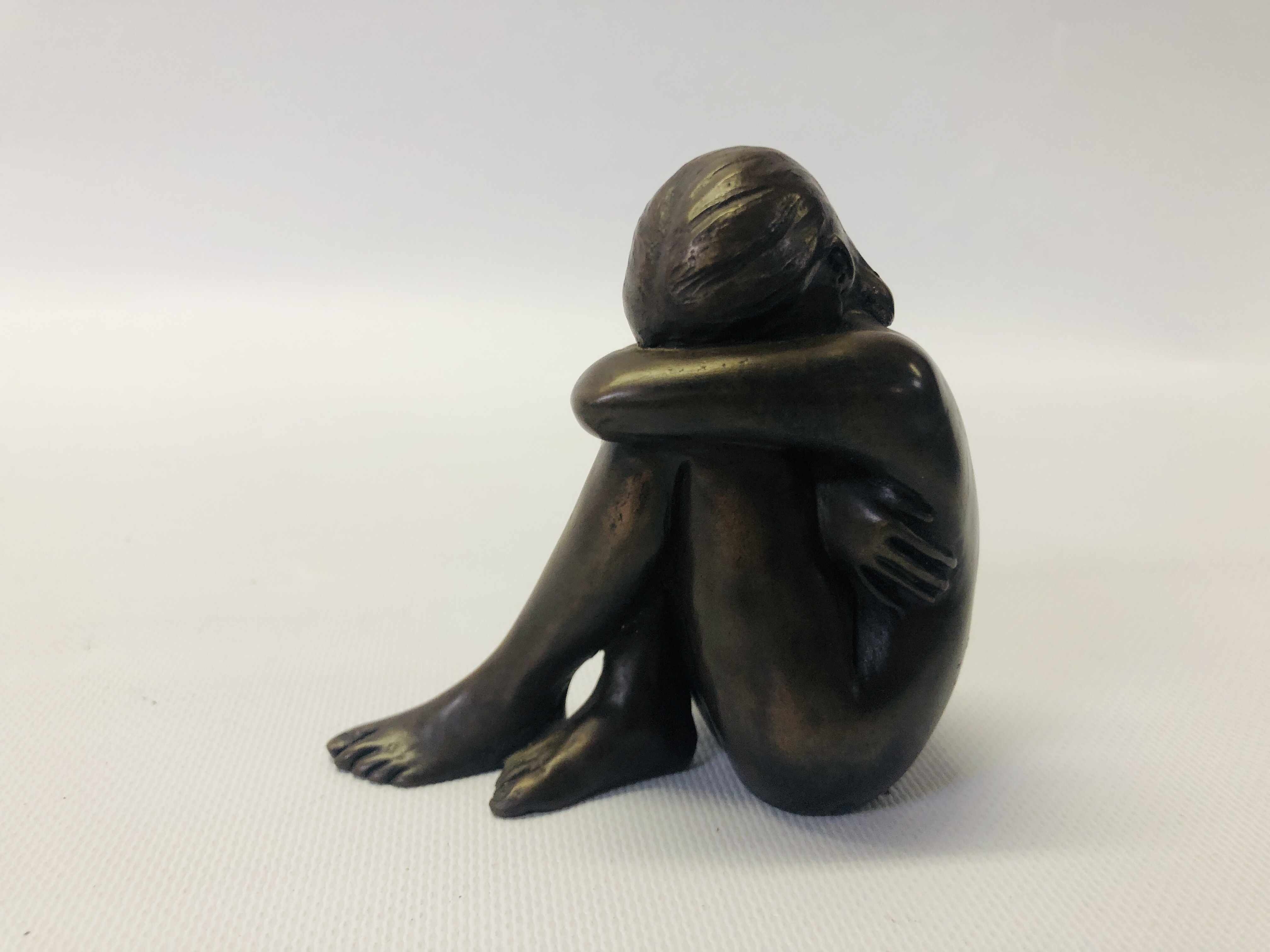 A CAST FIGURE BY D.J. SCALDWELL 20TH CENTURY MODED AS A GIRL HUNCHED ...