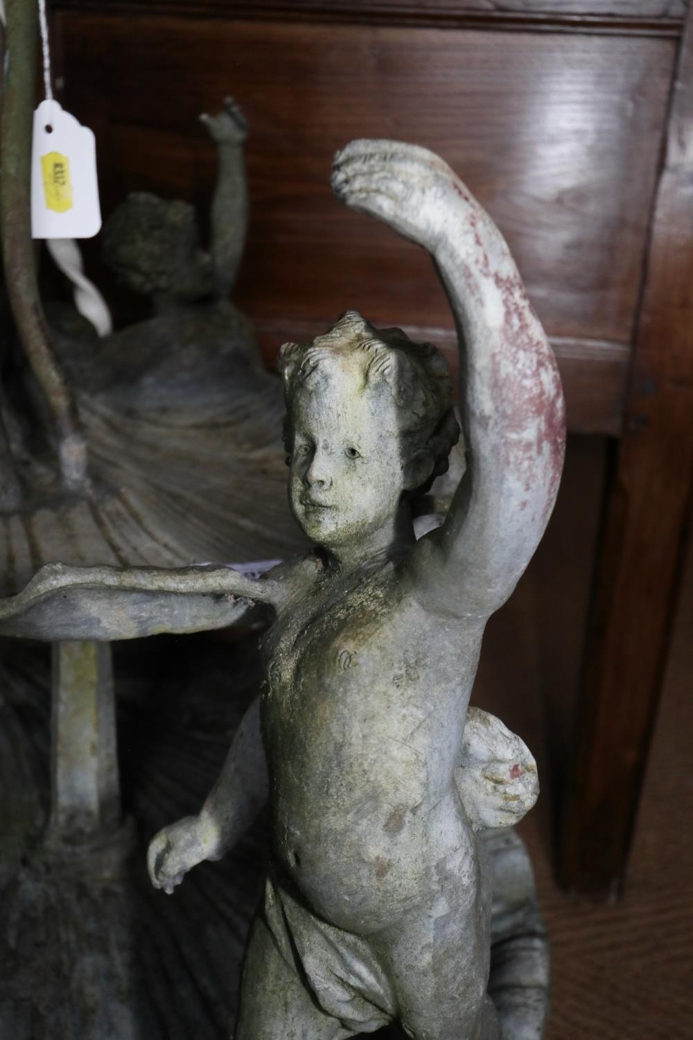 A cast lead two-tier shell and putti fountain, on dolphin triform base ...