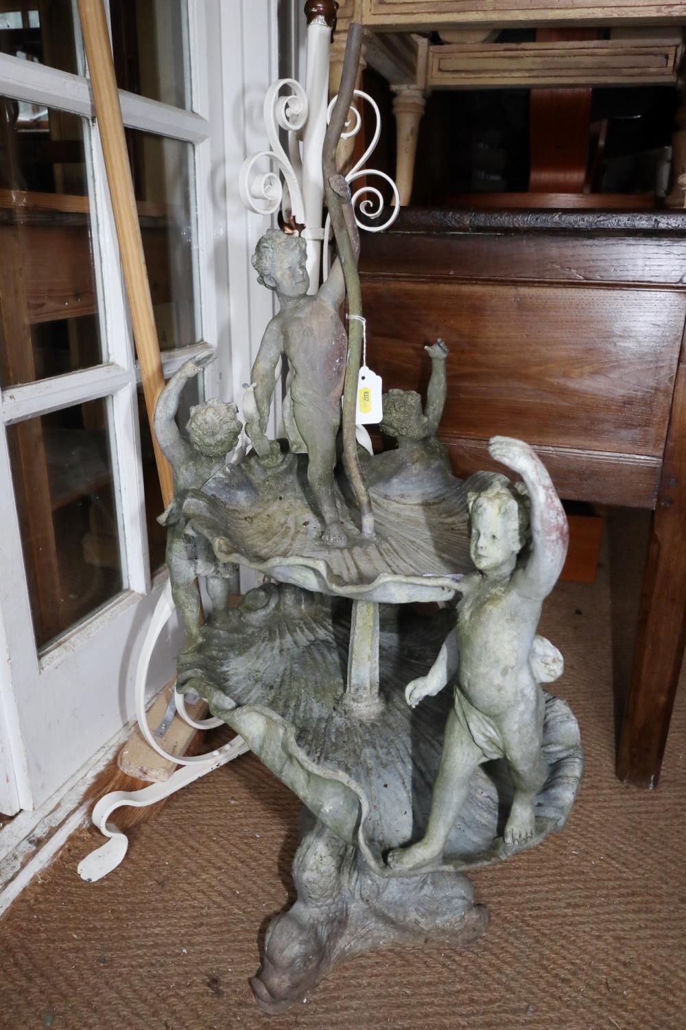 A cast lead two-tier shell and putti fountain, on dolphin triform base ...