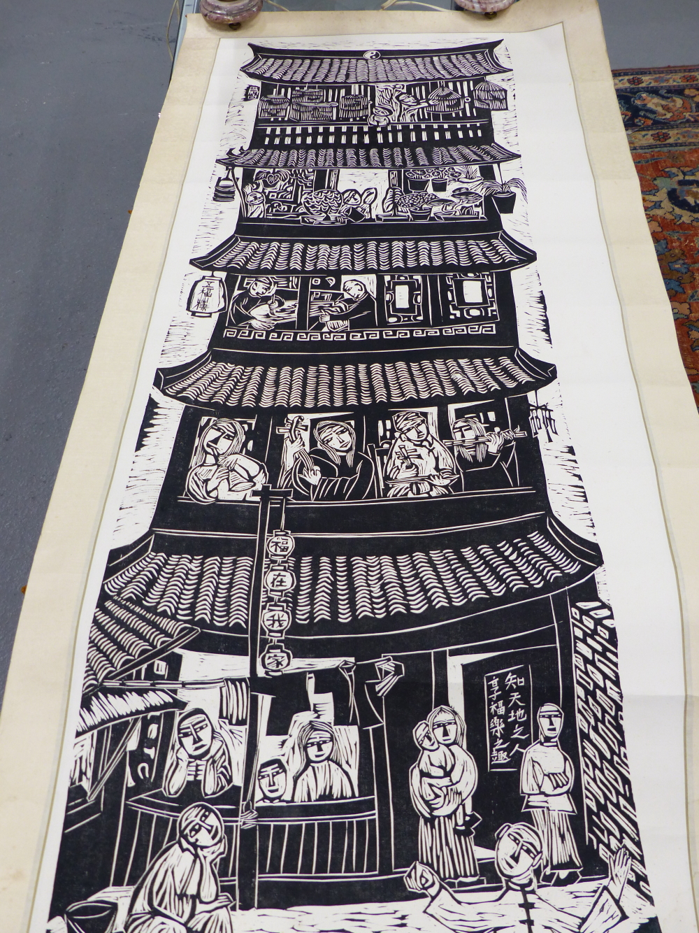 A CHINESE WOOD OR LINOCUT PRINT OF A HOME WITH FIGURES AT THE WINDOWS ...