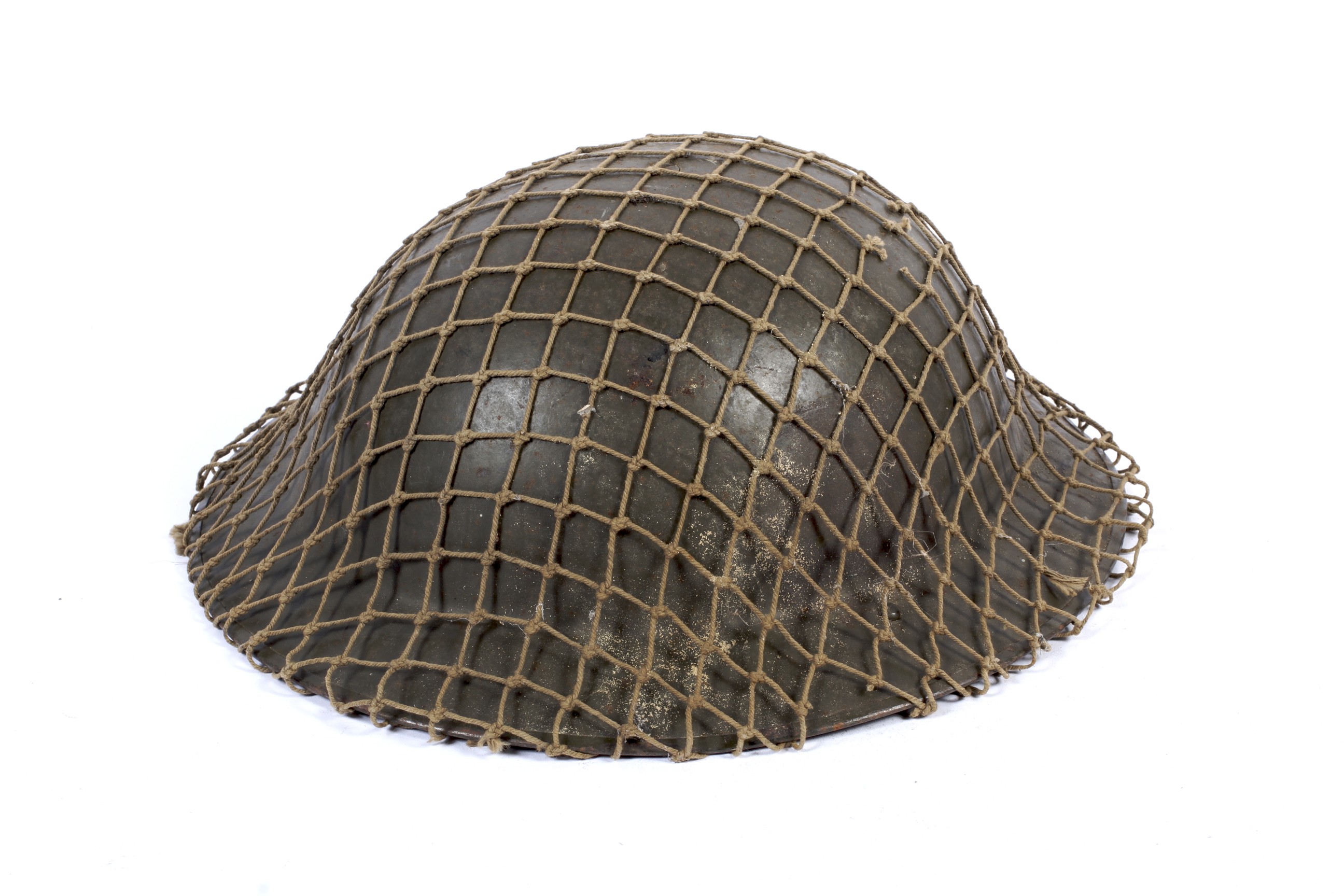 A British Brodie 'Tommy' steel helmet with net and leather lining. With ...