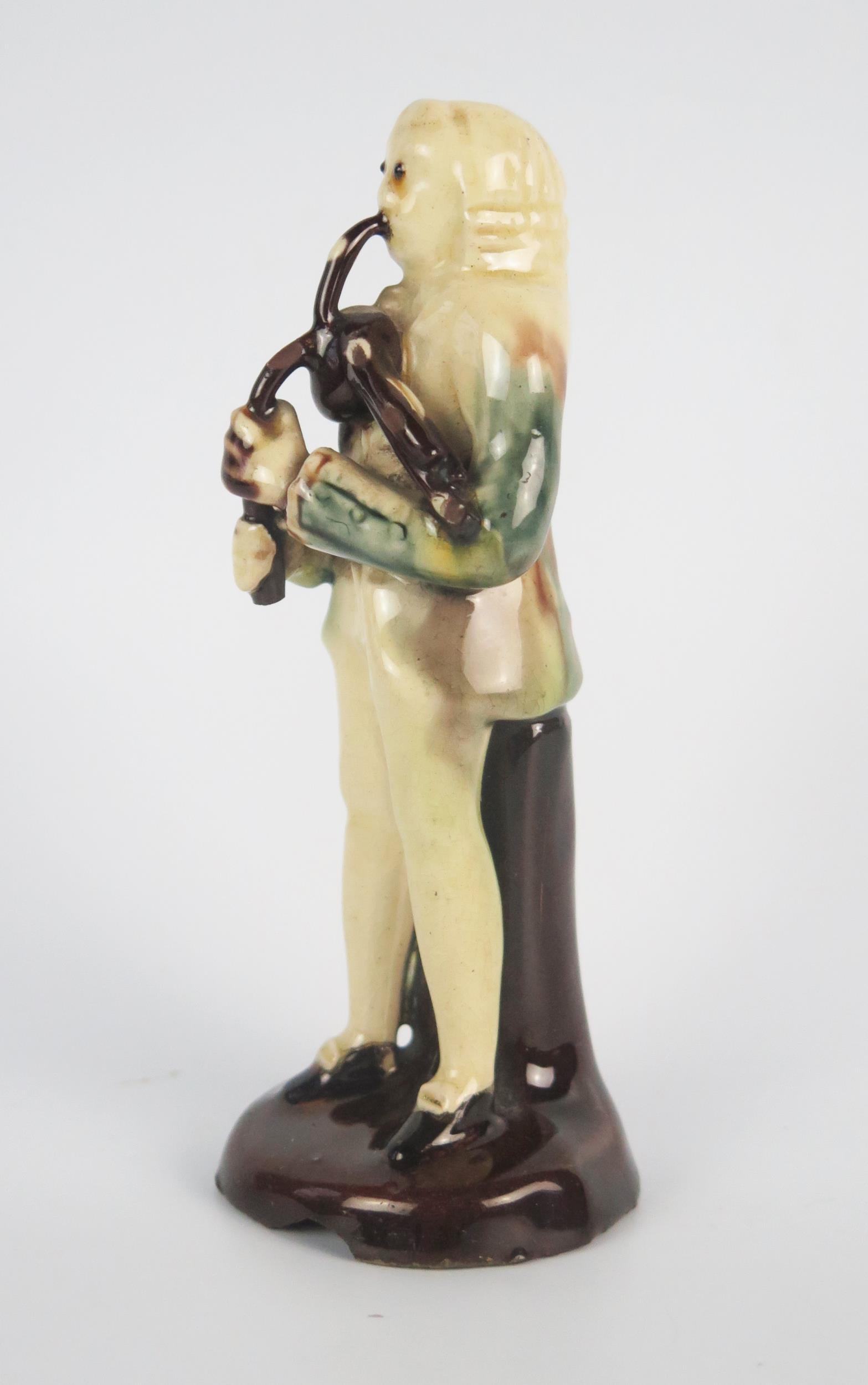An 18th century Astbury-Whieldon pottery figure of a piper, with brown ...