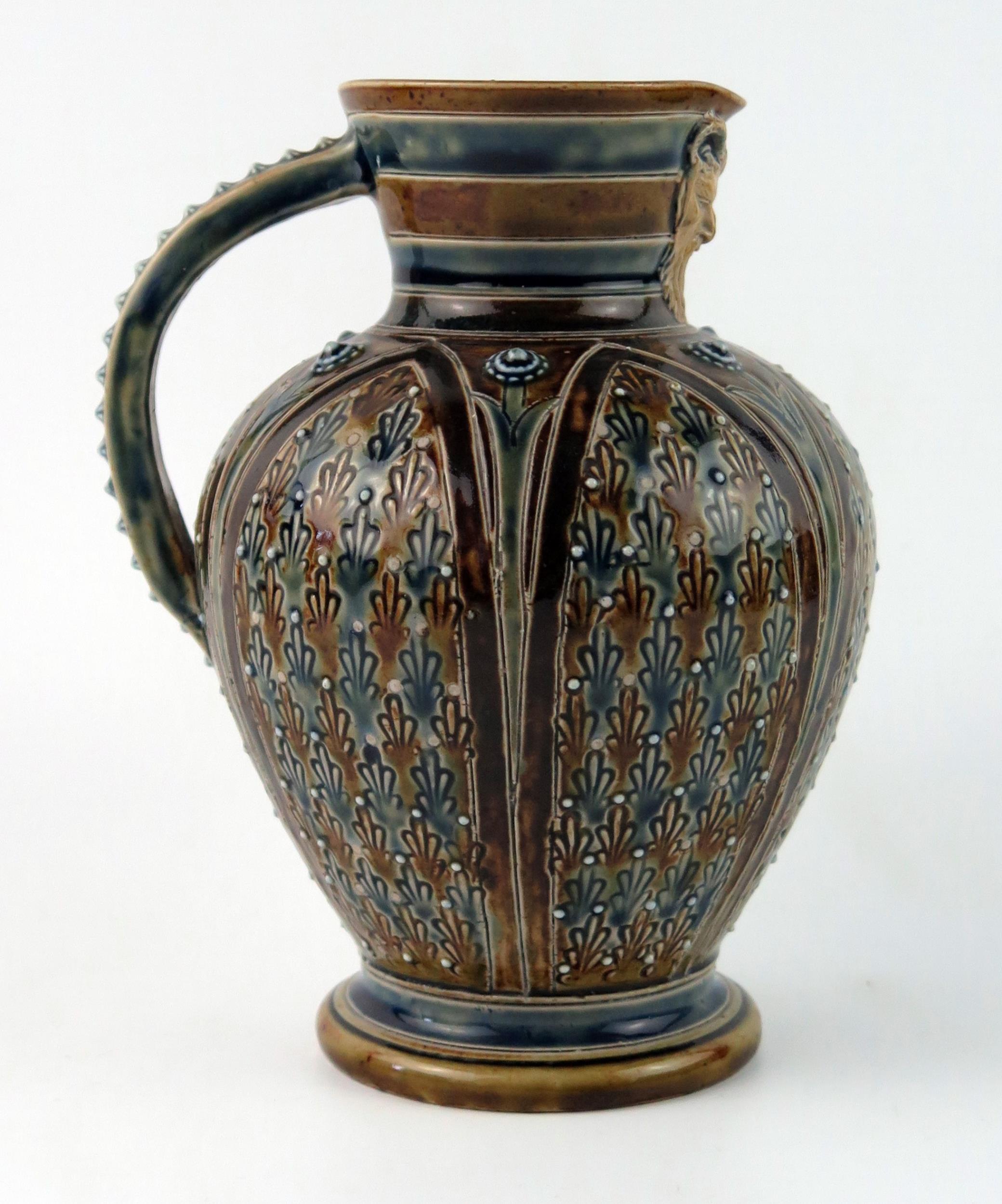 A Doulton Lambeth ware mask jug, of ovoid form, with impressed foliate ...