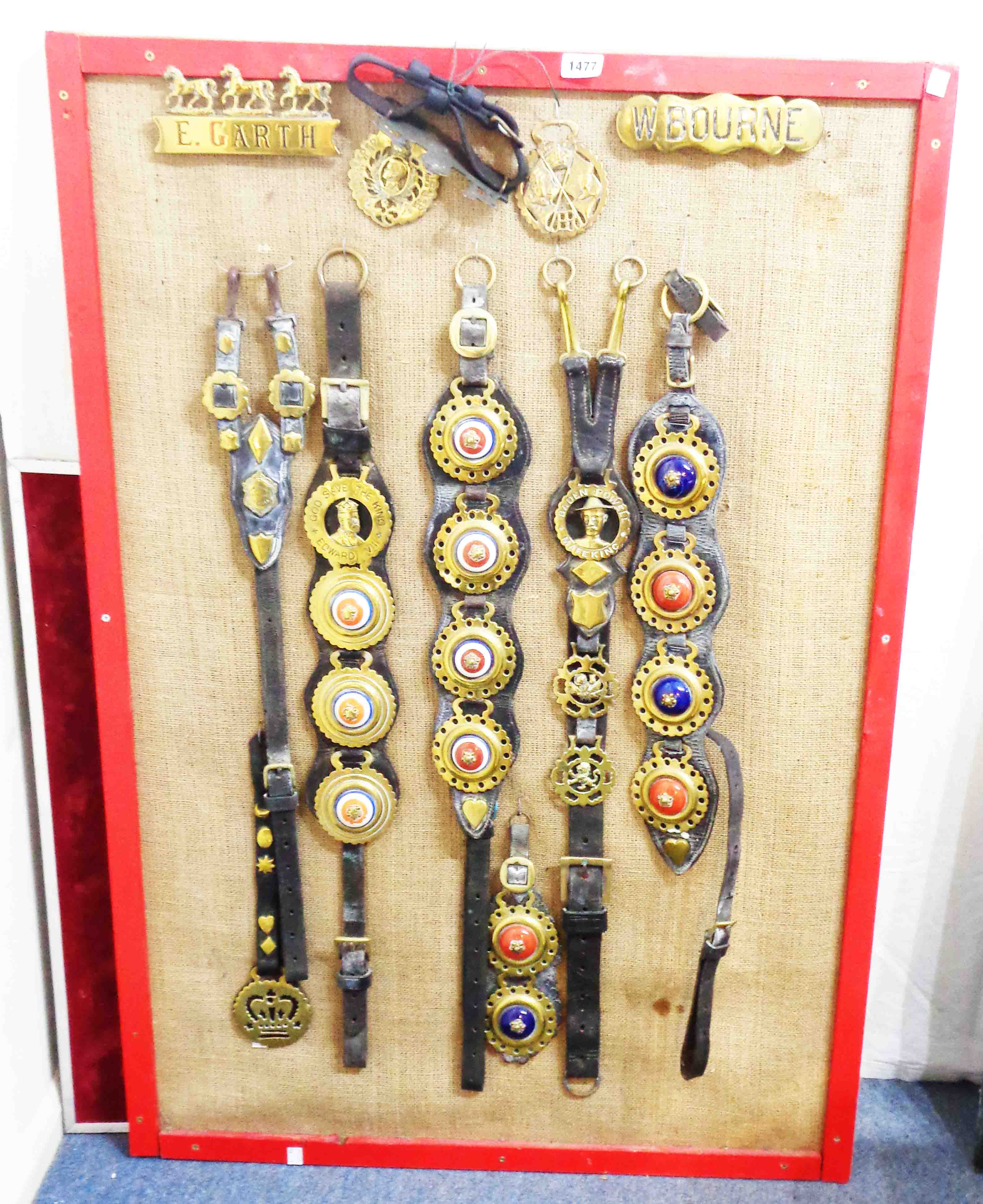 A wood and hessian display board set with a collection of horse brasses ...