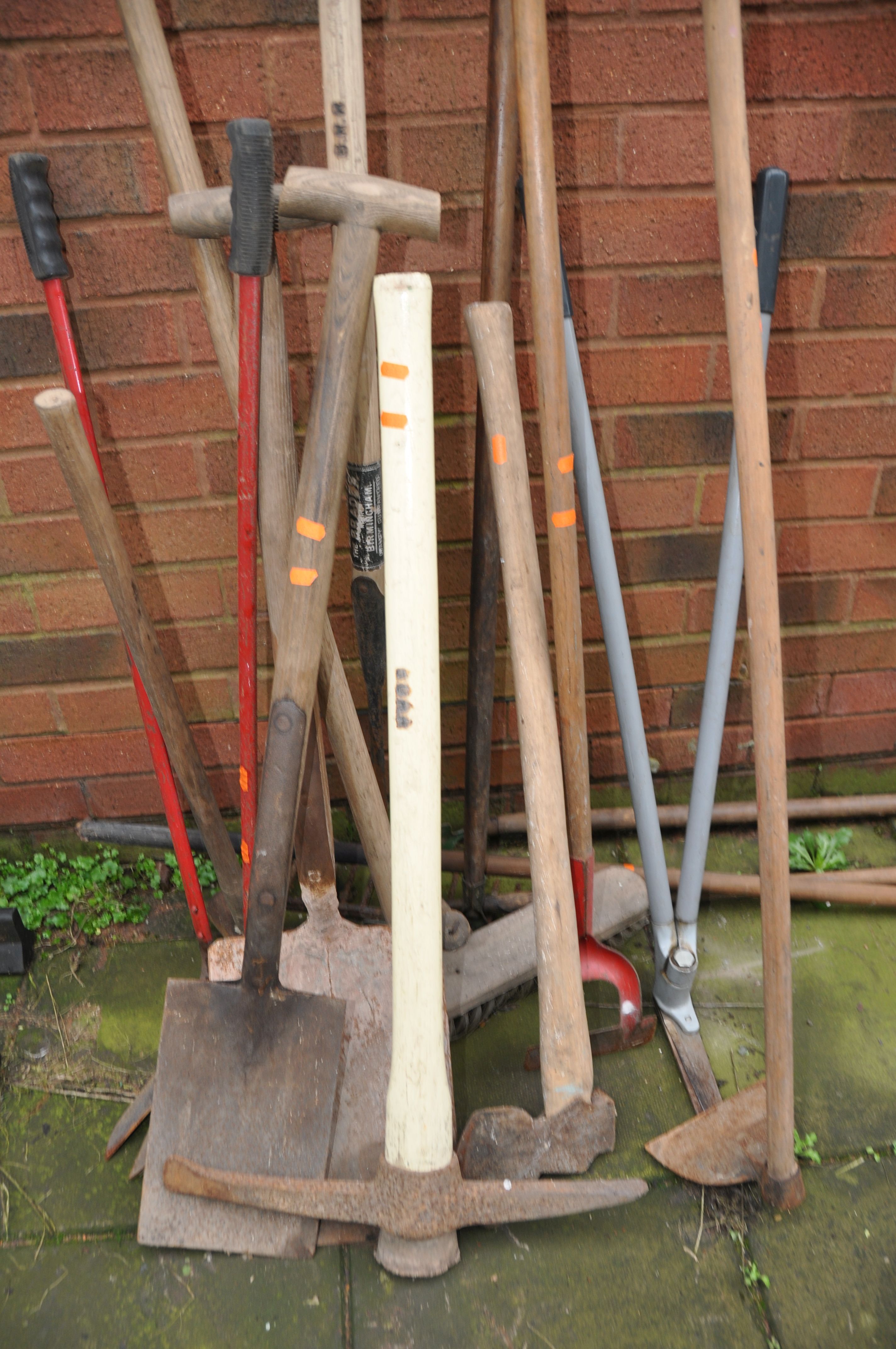 A COLLECTION OF GARDEN TOOLS to include rakes, spade, pick axe, sledge ...