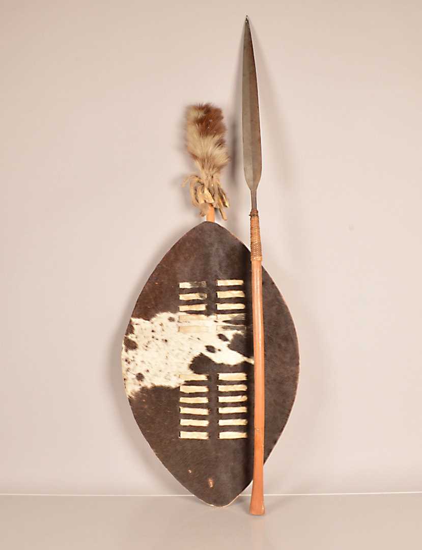 An Animal Hide Tribal Shield, together with a spear, having 46cm head ...